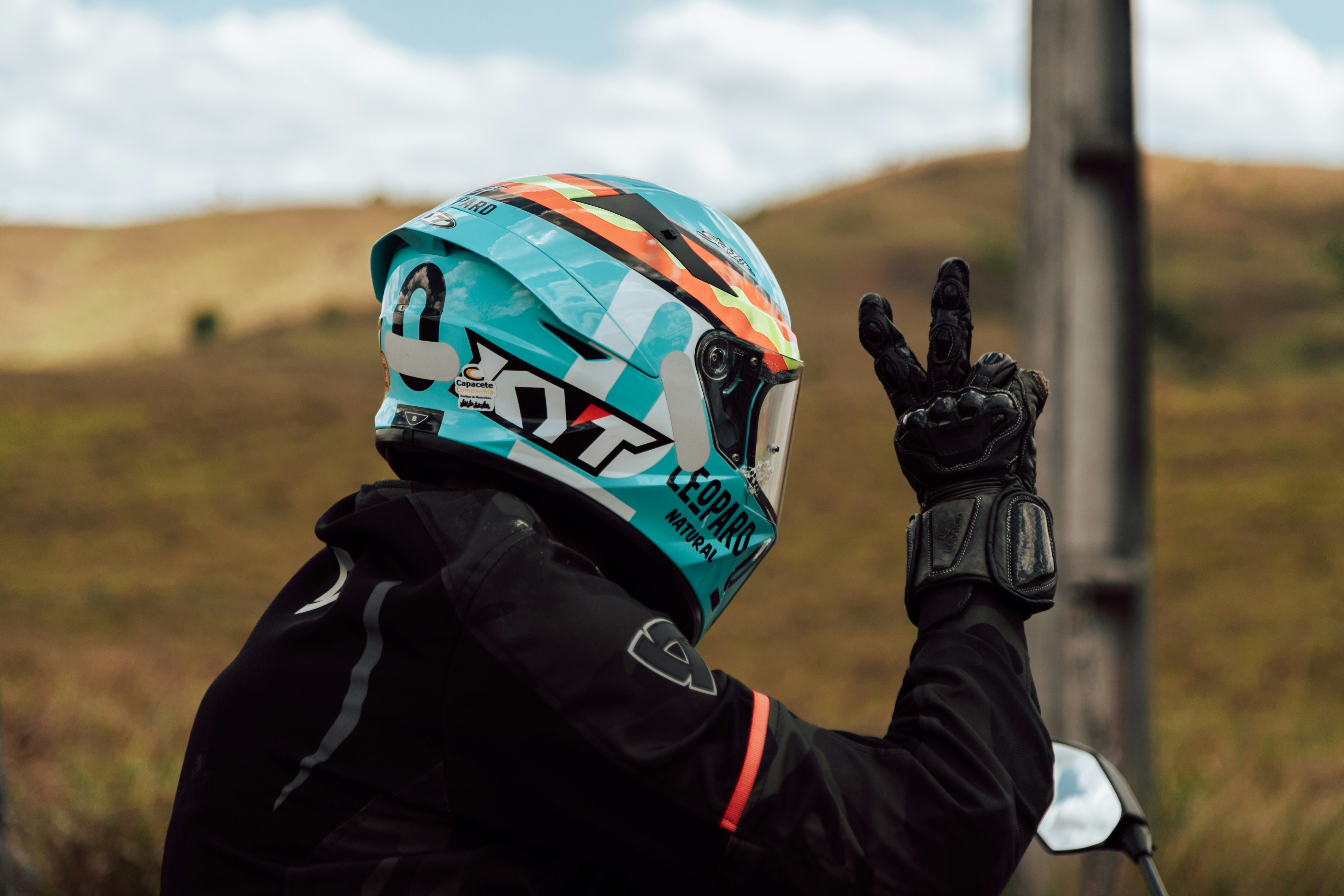A person wearing a helmet and holding up a peace sign photo – Free Man ...