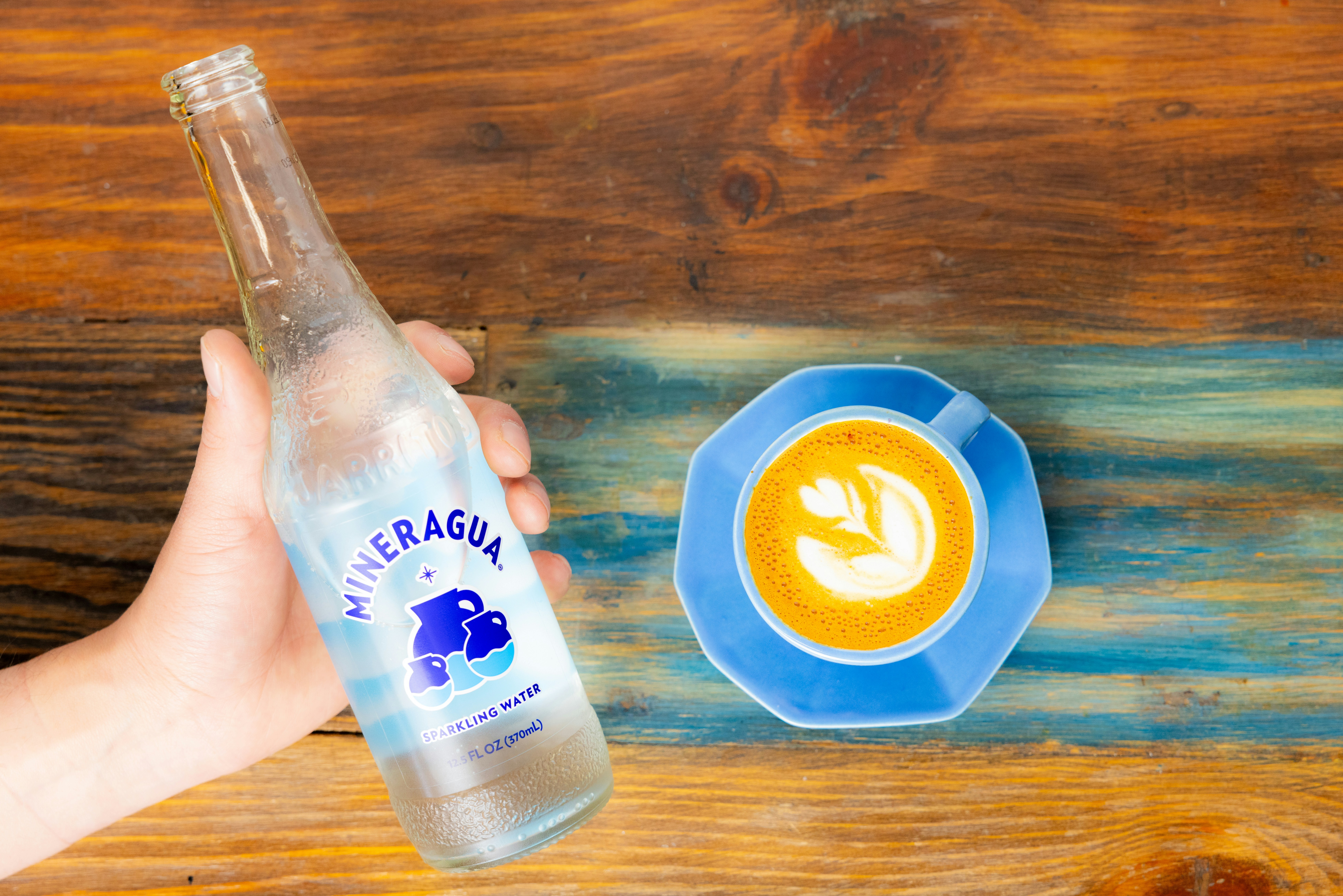 Clear Spark: A Handful of Mineral Water Beside a Blue Cup