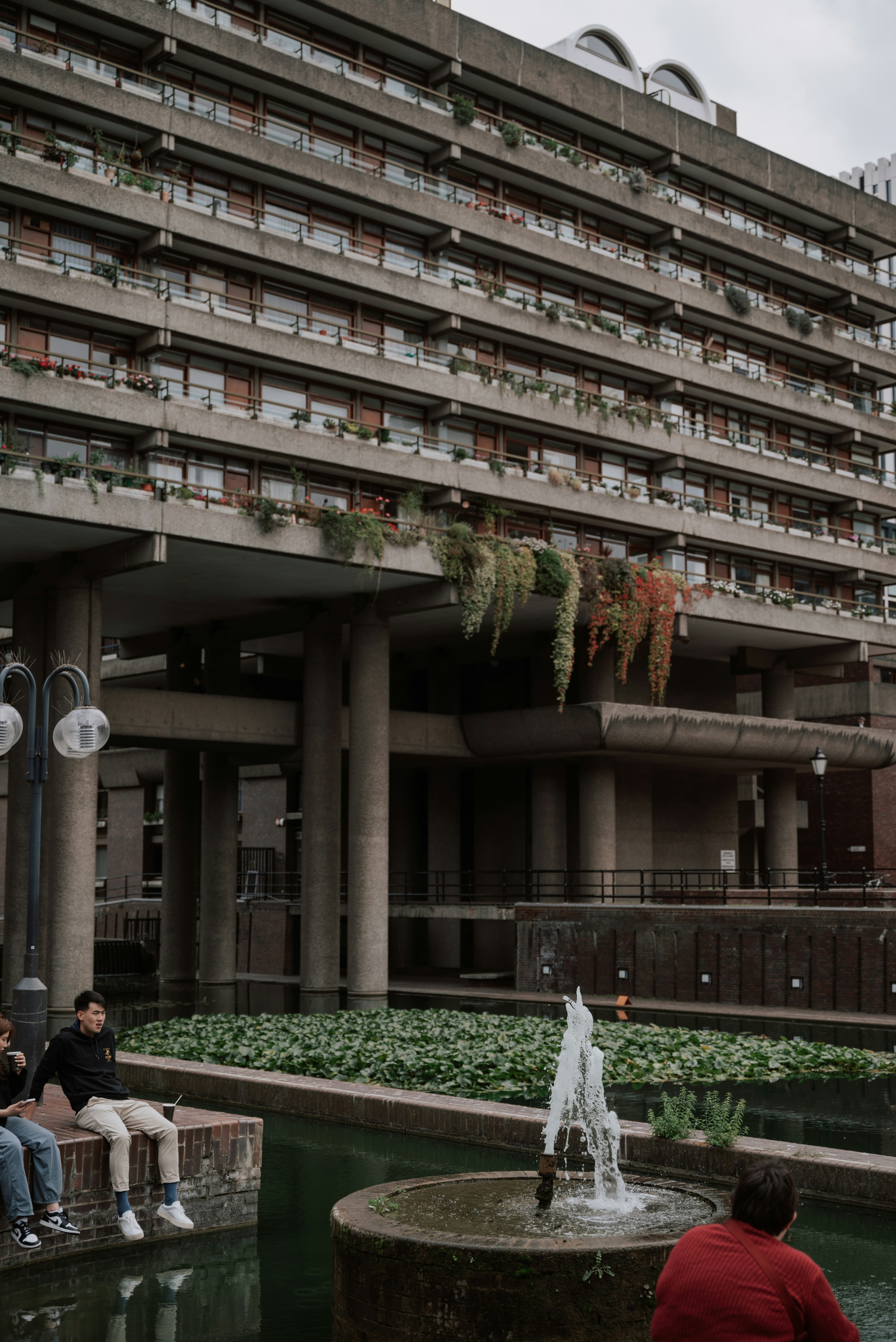 Foto zum Thema Eine Gruppe von Menschen, die um einen Brunnen vor einem ...