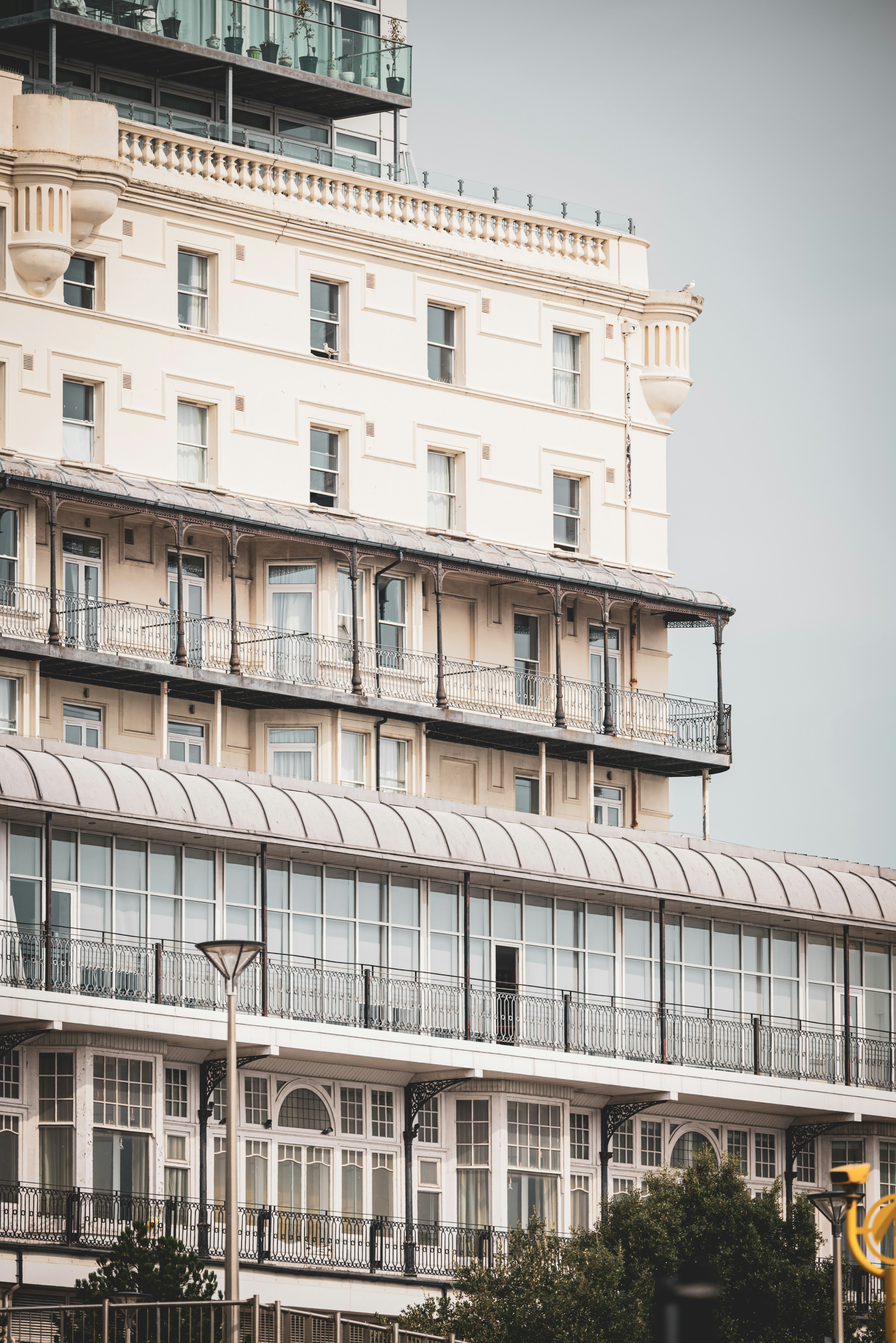Detailed view of a historic building showcasing intricate balconies and large windows, reflecting a blend of classic and modern architecture.