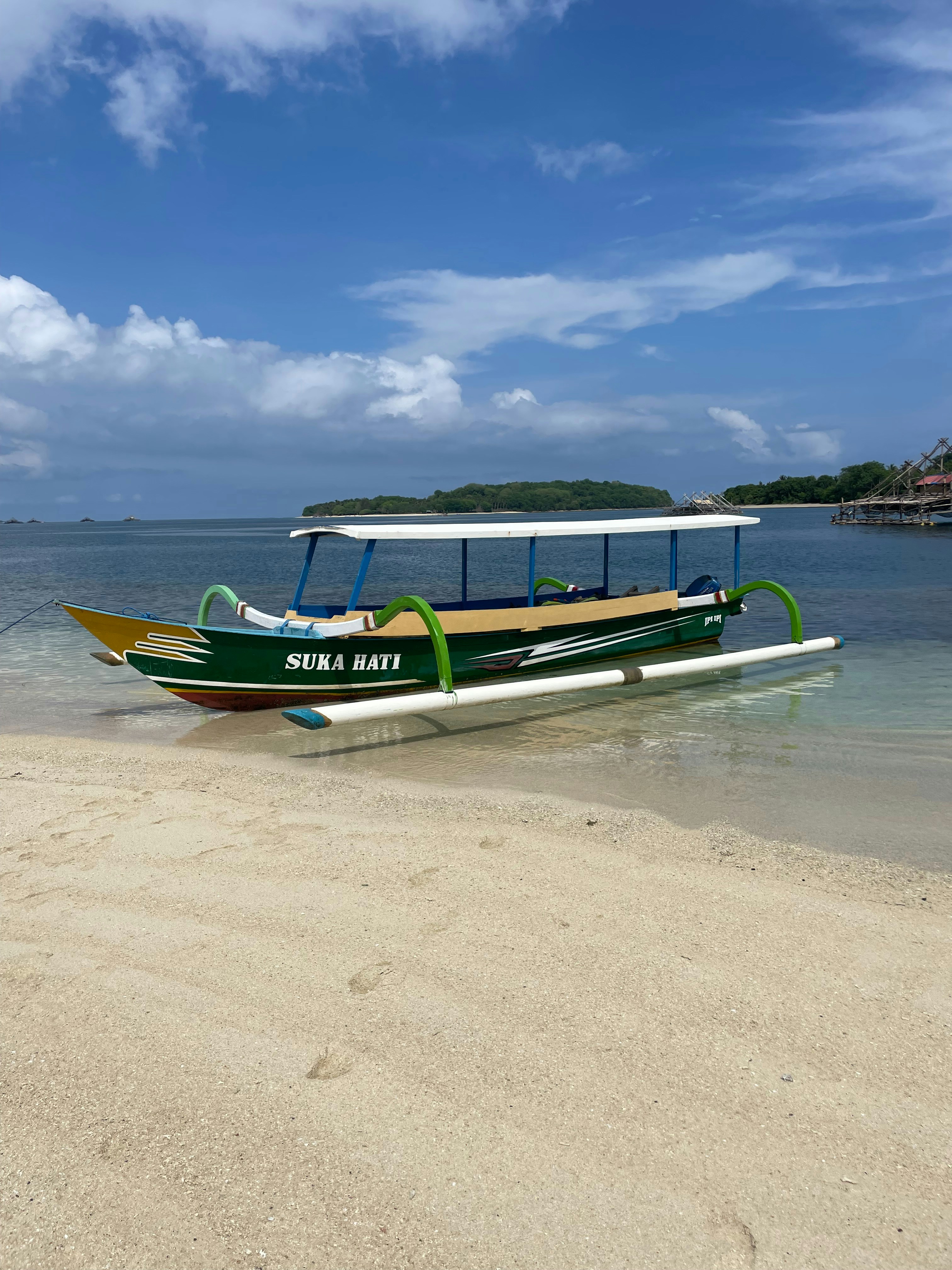 Suka Hati at the Quiet Shore: An Outrigger Resting on Sunlit Sand