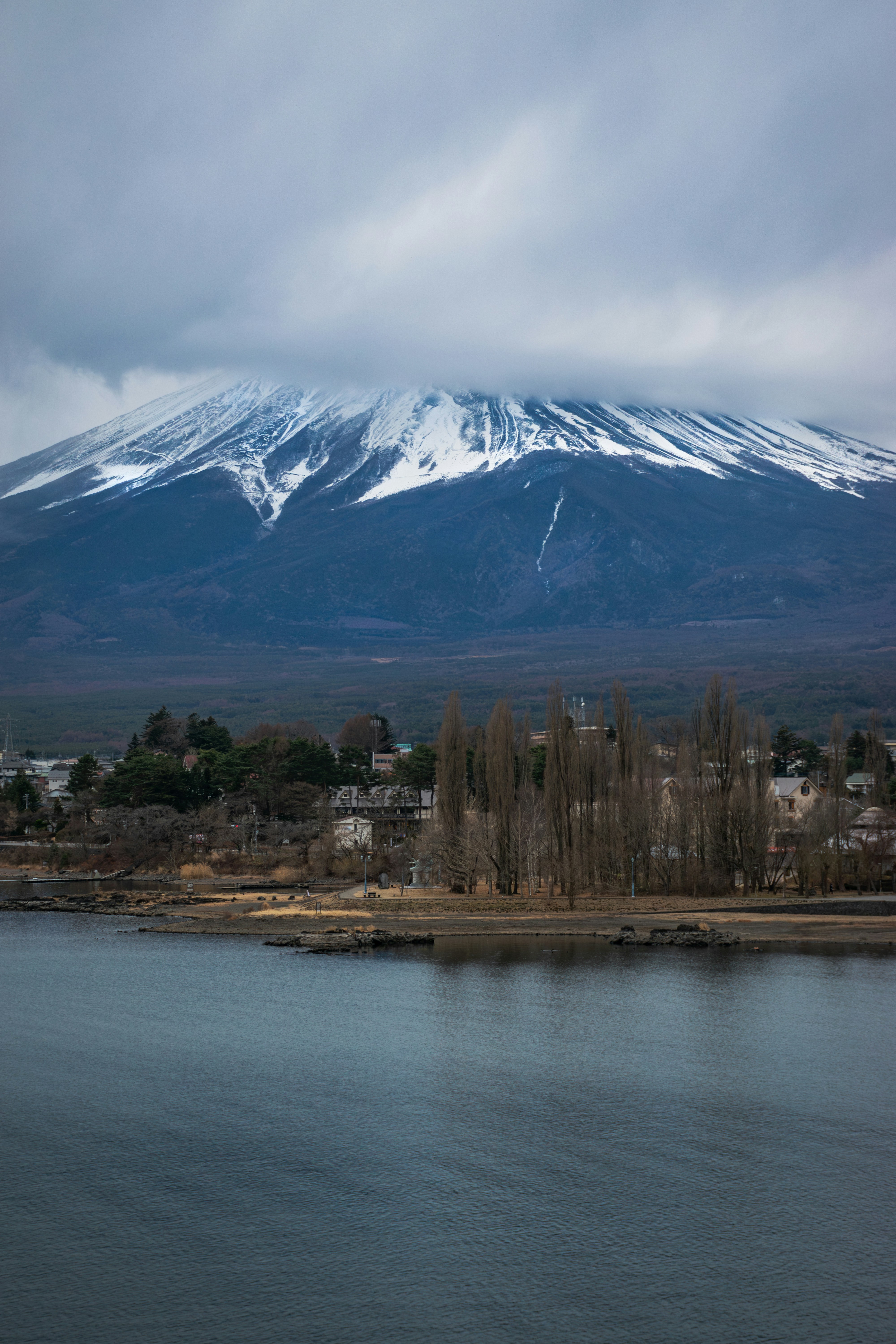 Snow-Crowned Summit Looms Over a Calm Lakeside Village