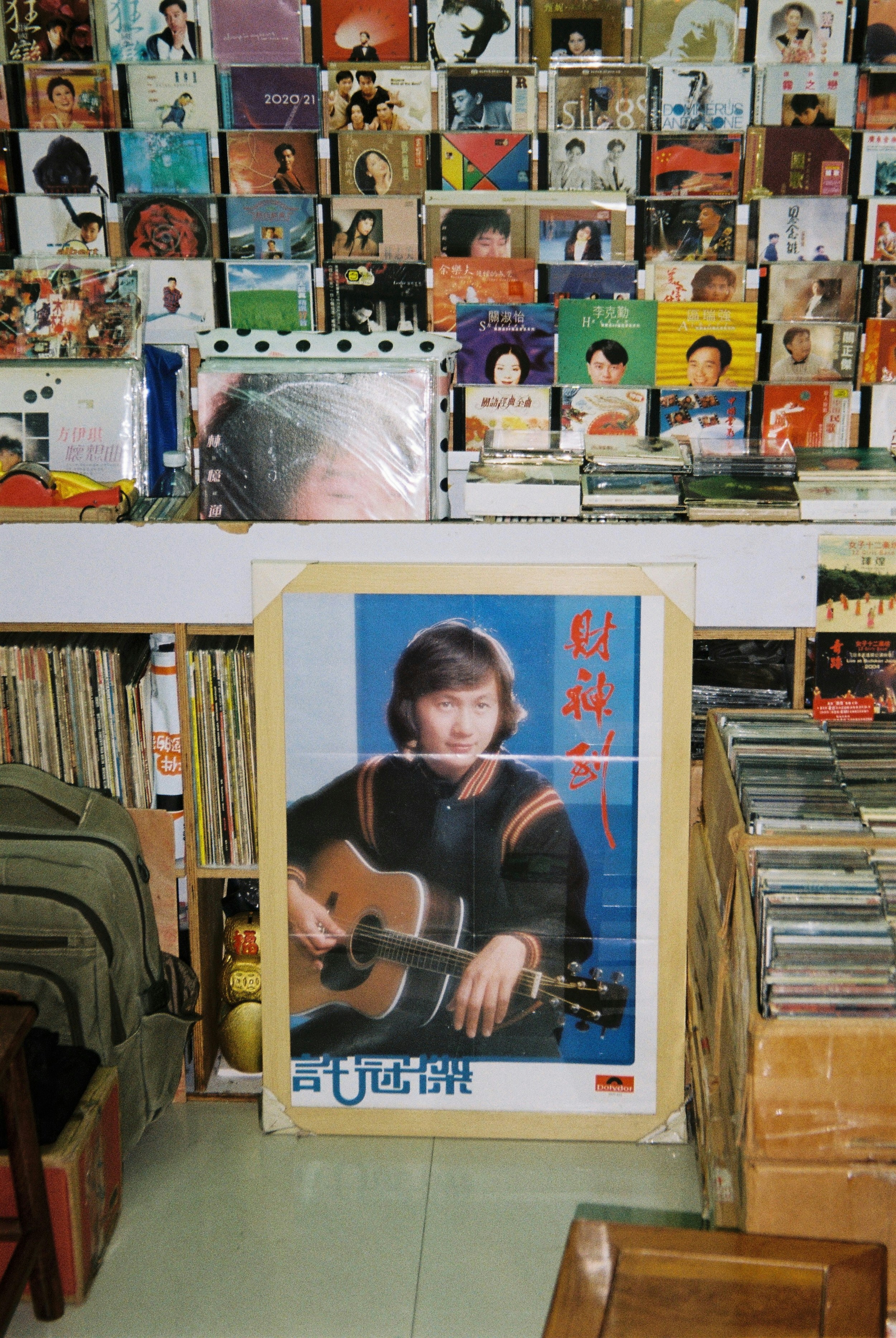 A picture of a man playing a guitar in a room full of records photo ...