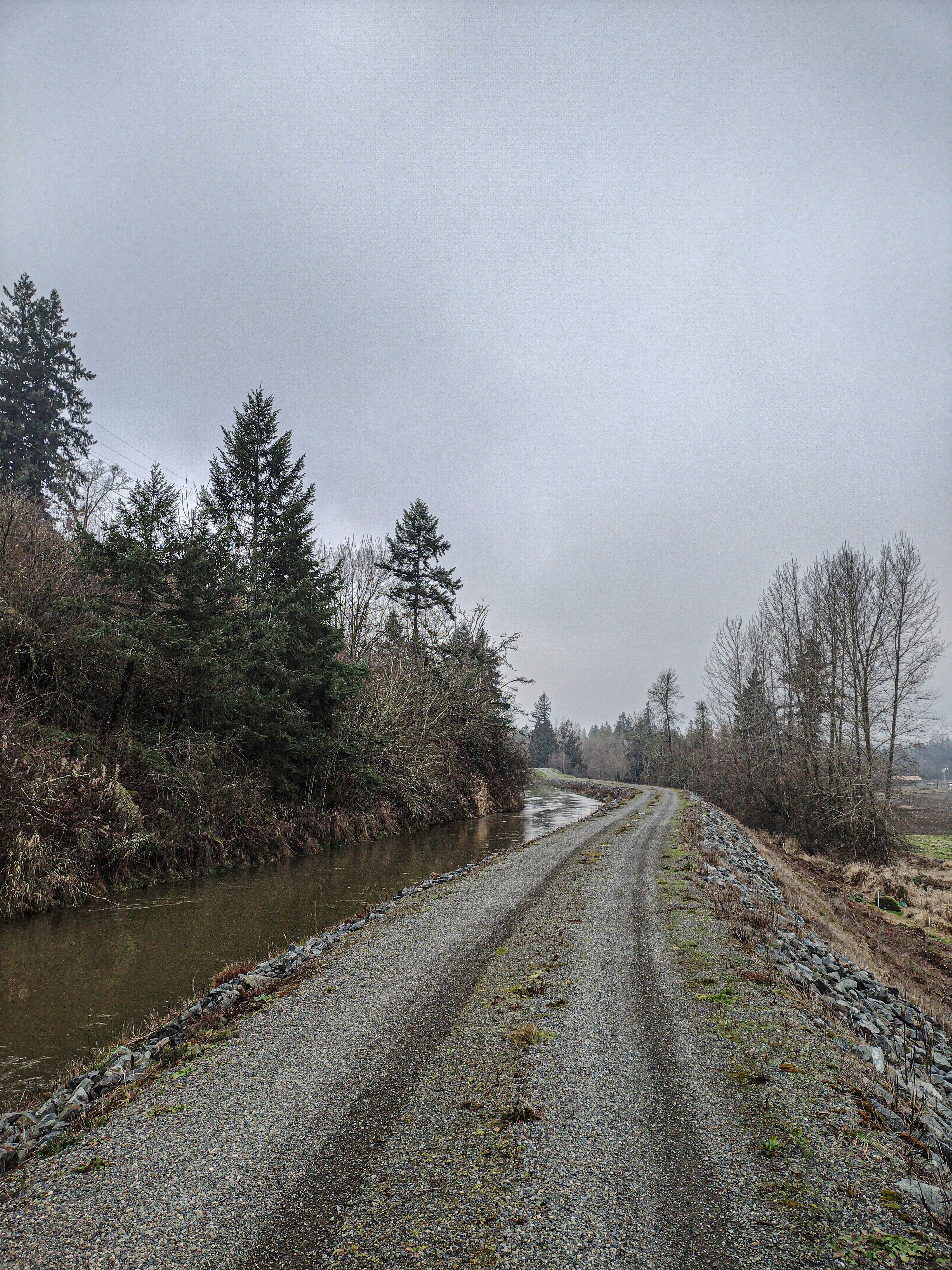 Gravel Causeway Over a Narrow Channel Under a Cloudy Sky