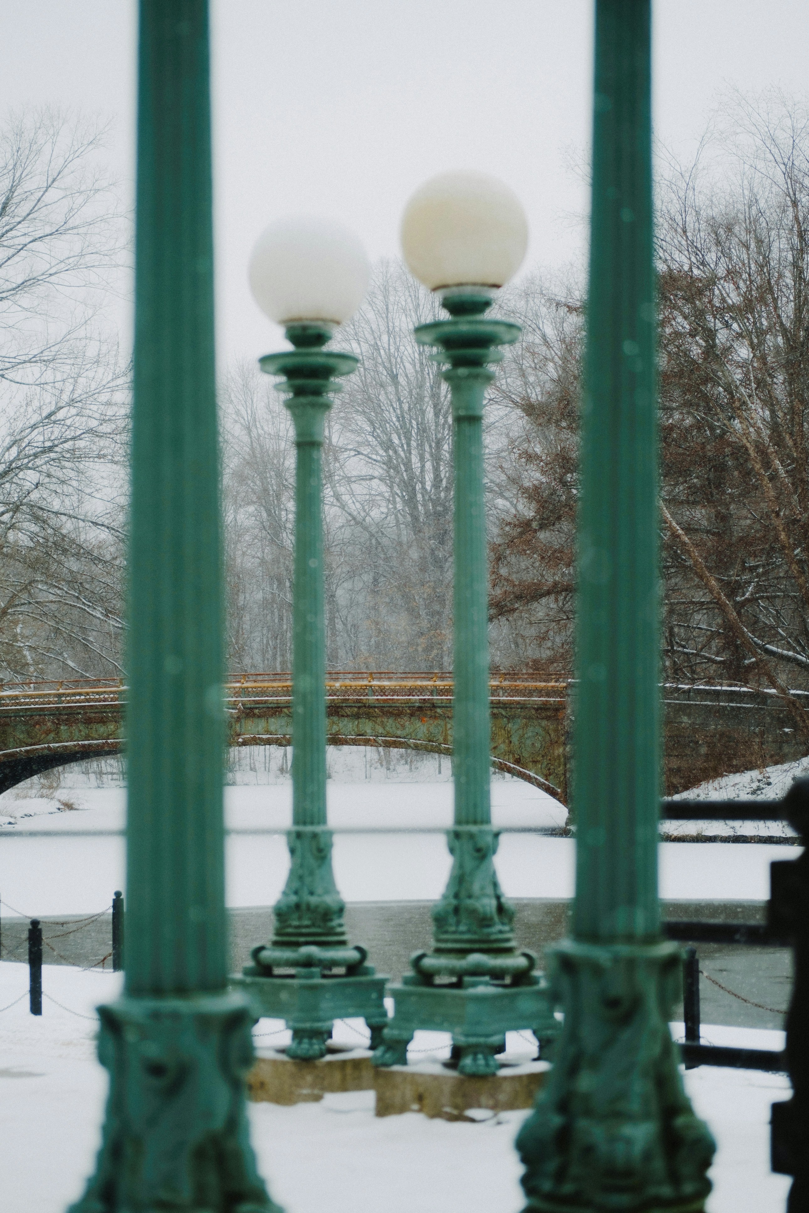 Verdigris Lanterns Framing a Snowbound Riverside