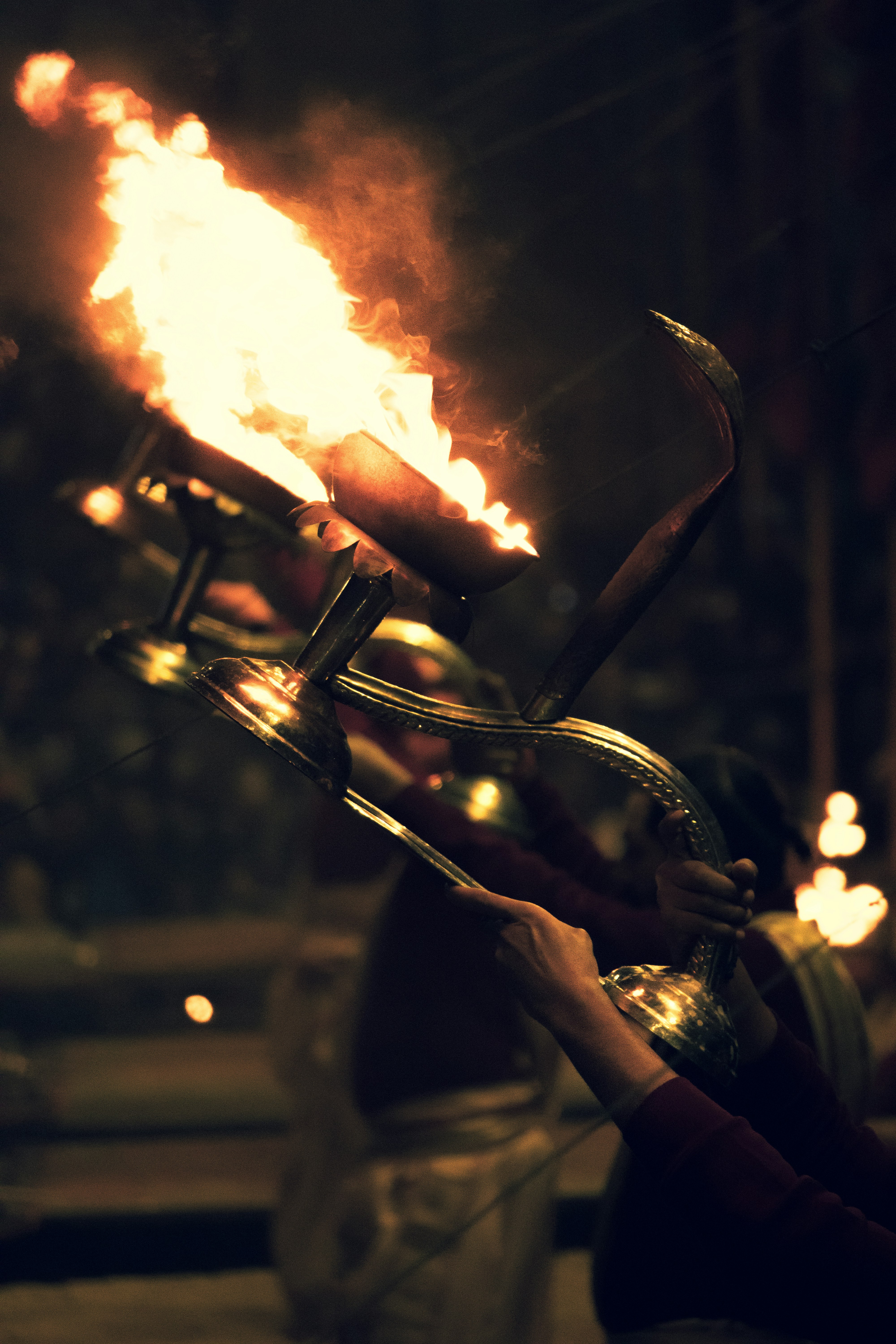 A person holding a metal object with flames coming out of it photo ...