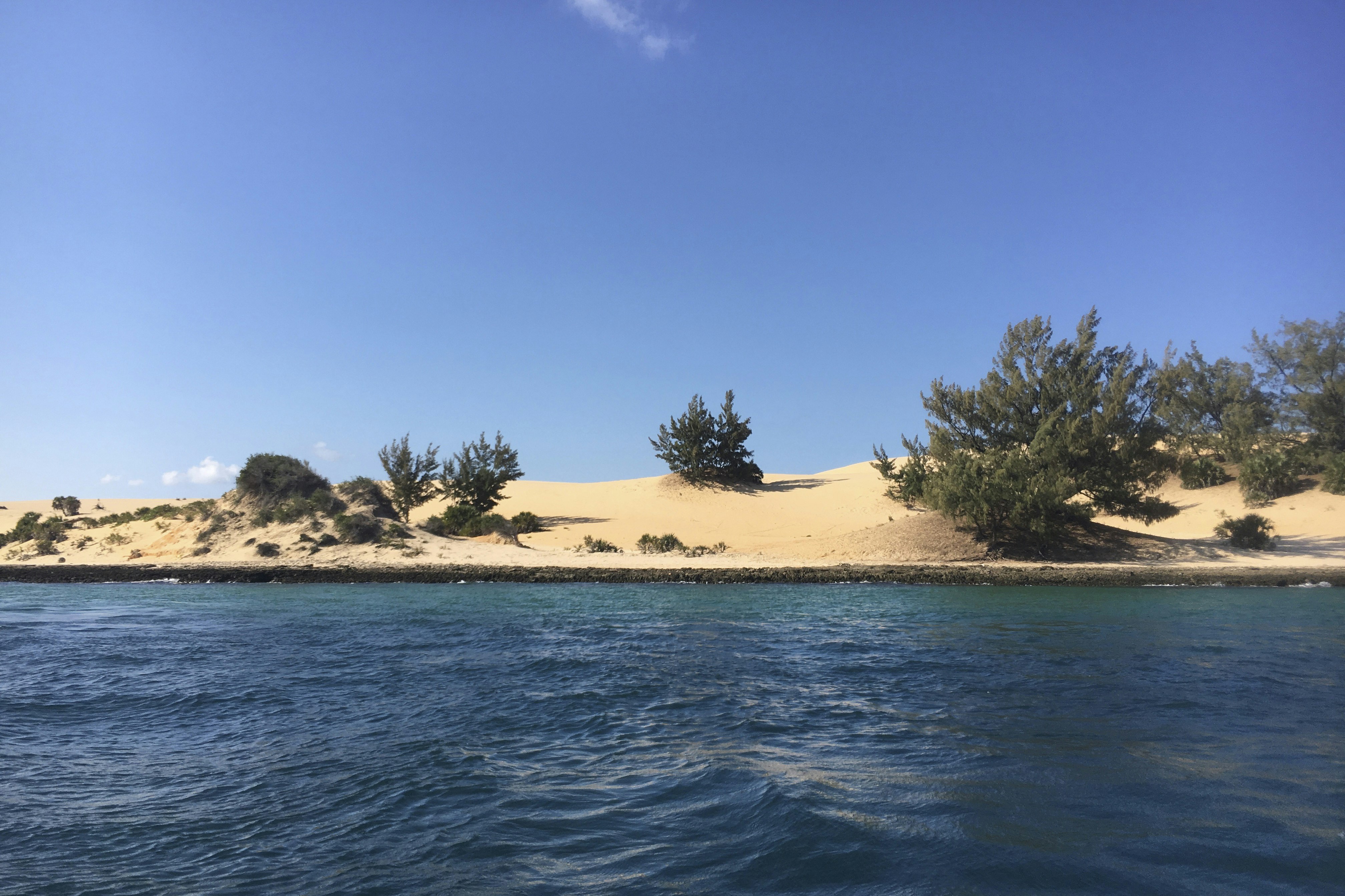 Deserted shoreline beneath a clear coastal sky