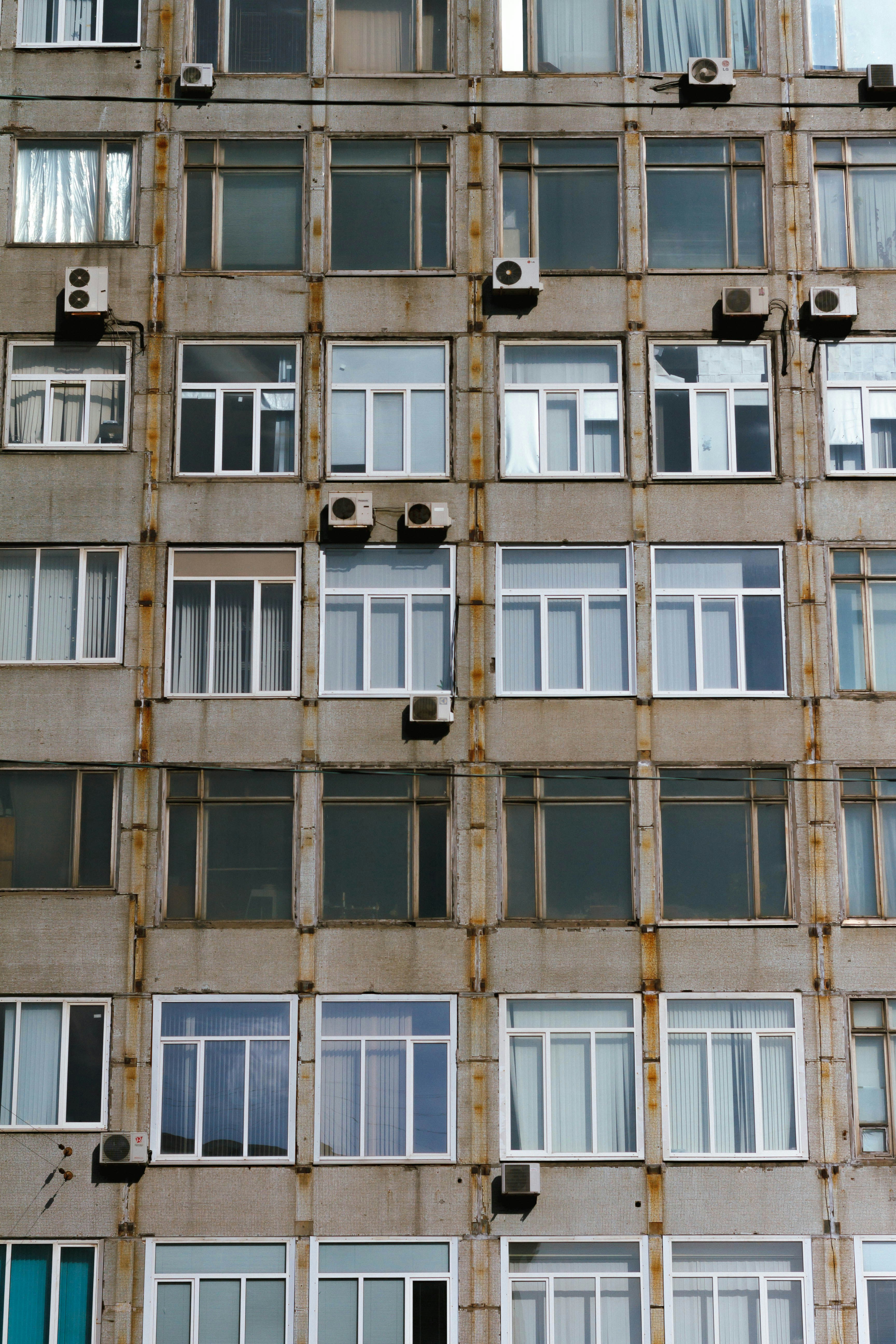 Rusted Grid: Weathered Concrete Facade of a Repeating Window Block