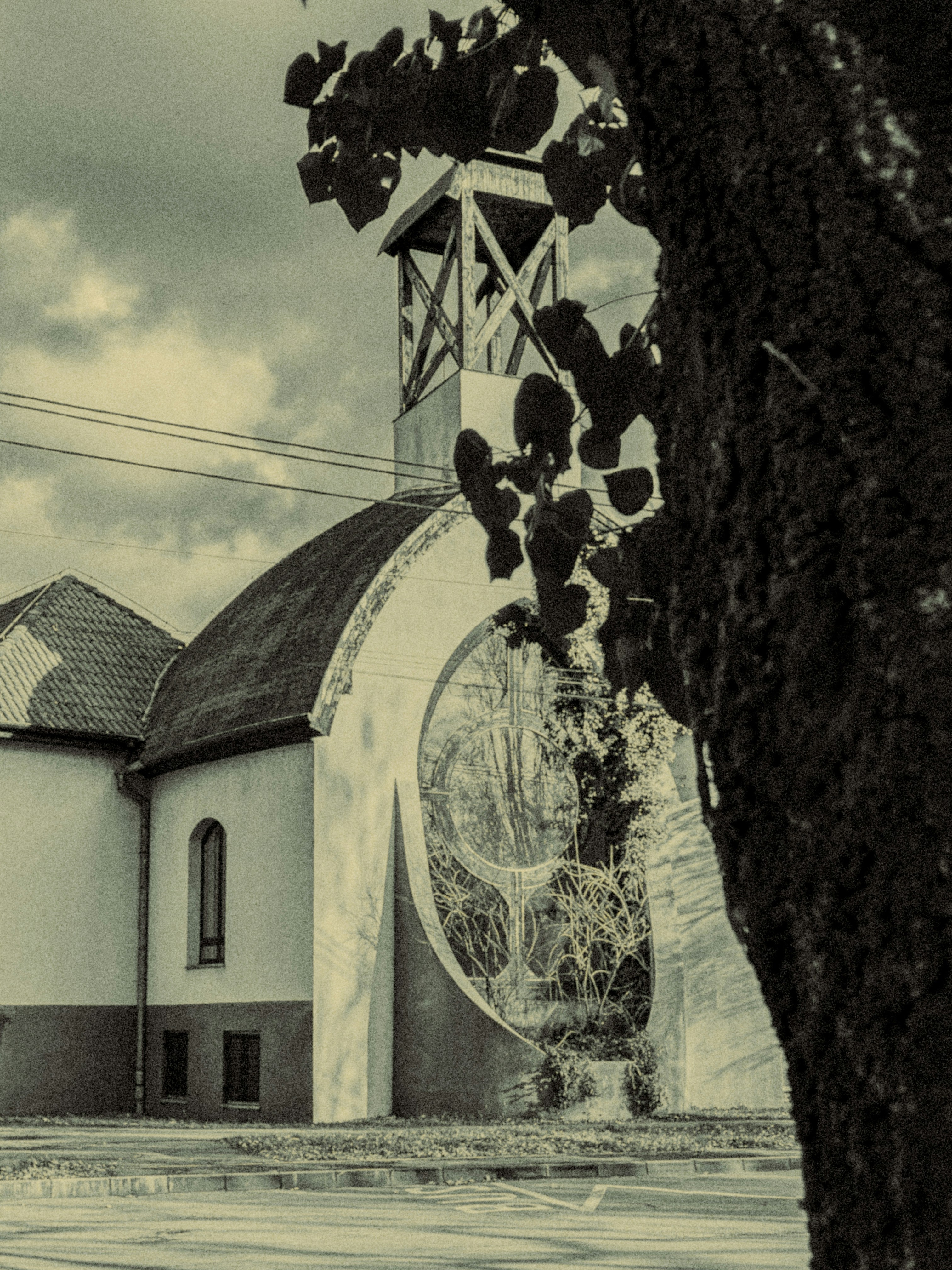 Weathered Chapel Circle: Light Through a Circular Window Framed by Foliage