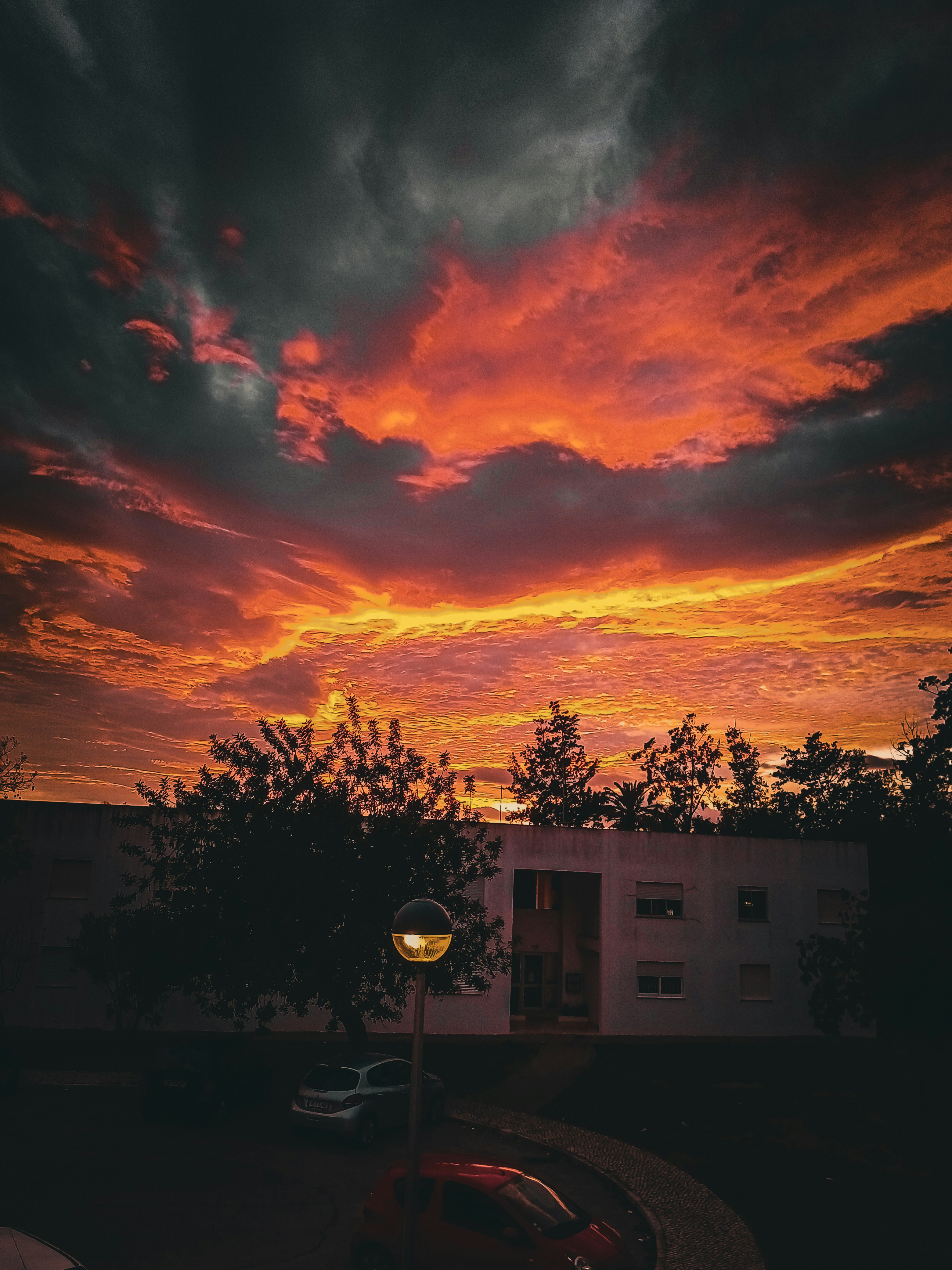 a red and orange sunset over a white building