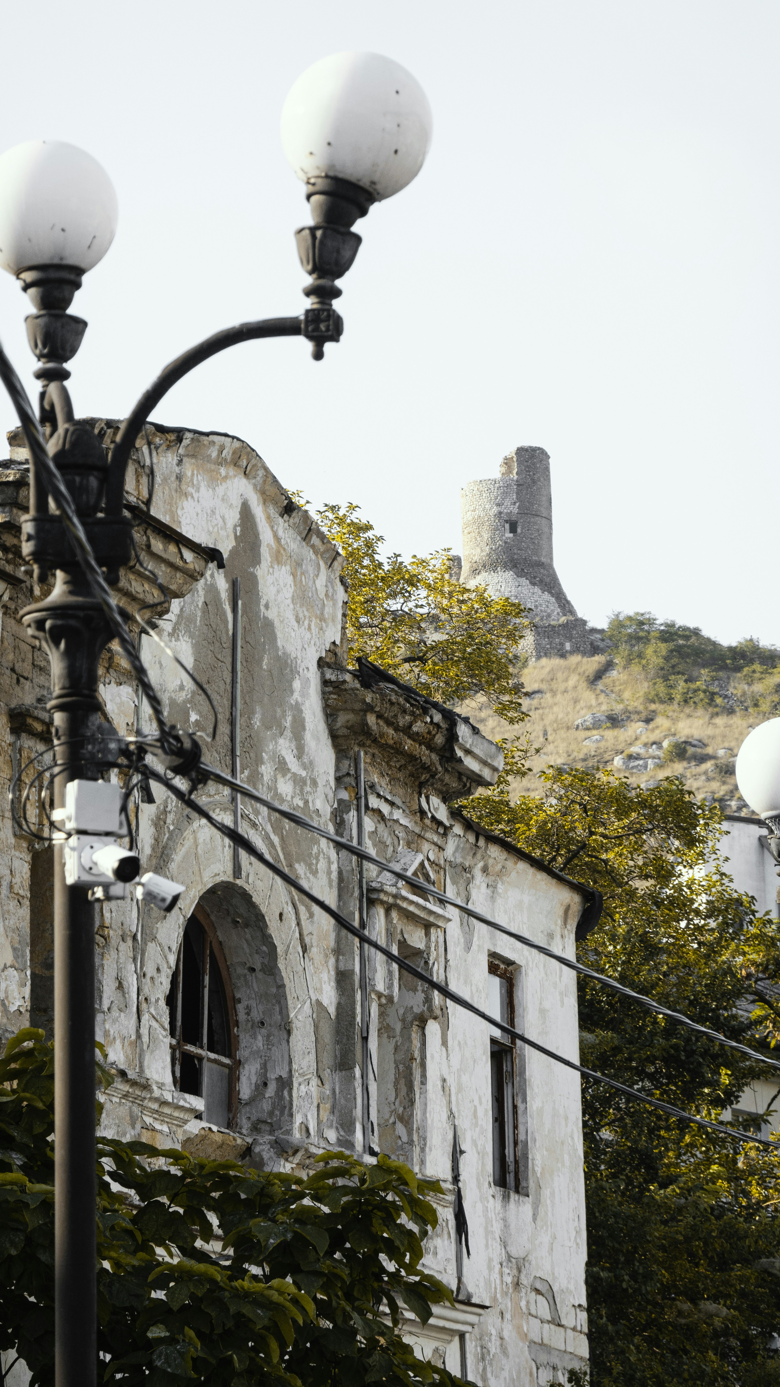 Lanterns and a Hilltop Keep: A Weathered Street Scene