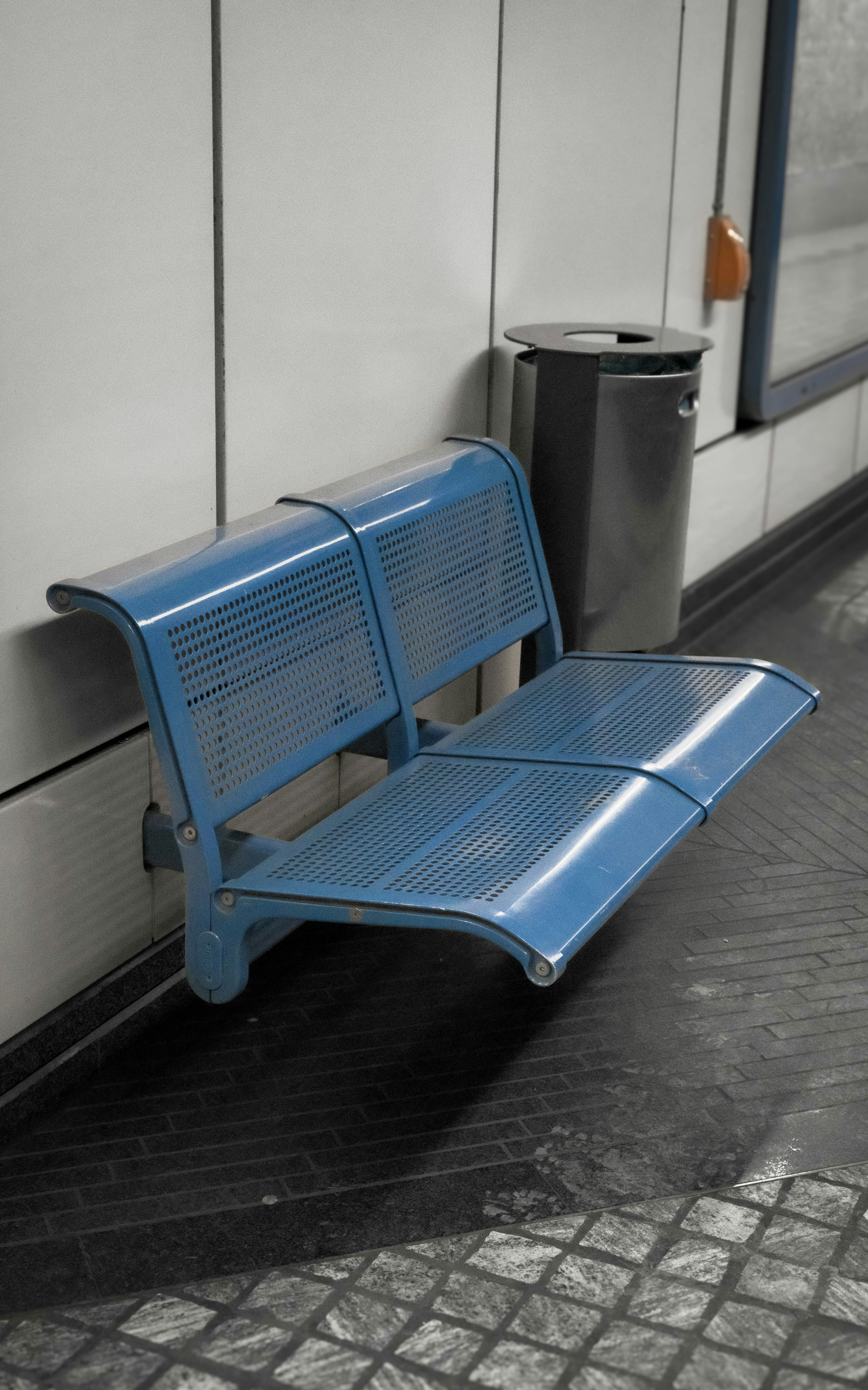 Blue Perforated Bench at a Quiet Platform Edge