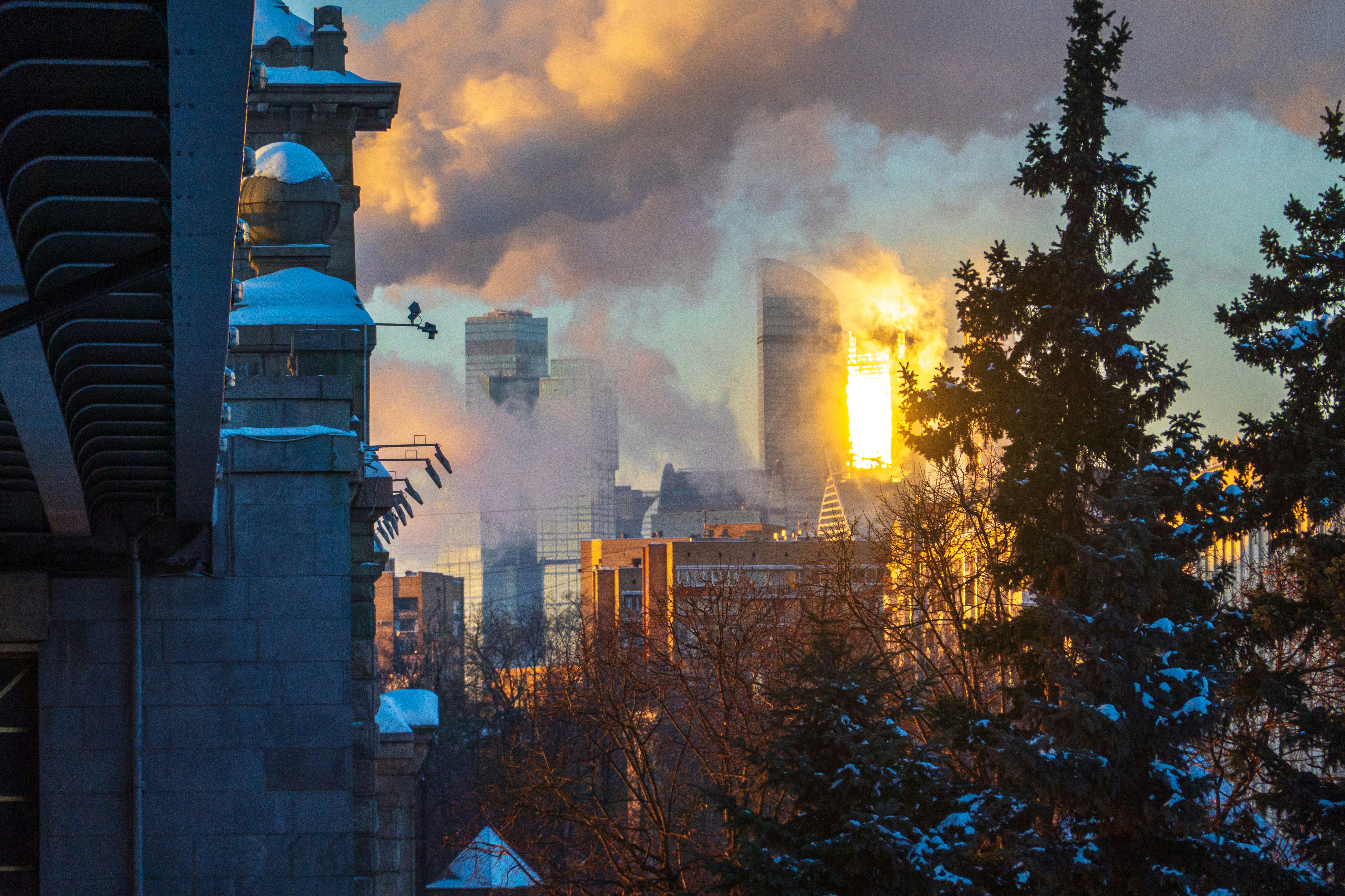 Sunset's fiery glow reflects off Moscow City skyscrapers with steam rising on a frigid day
