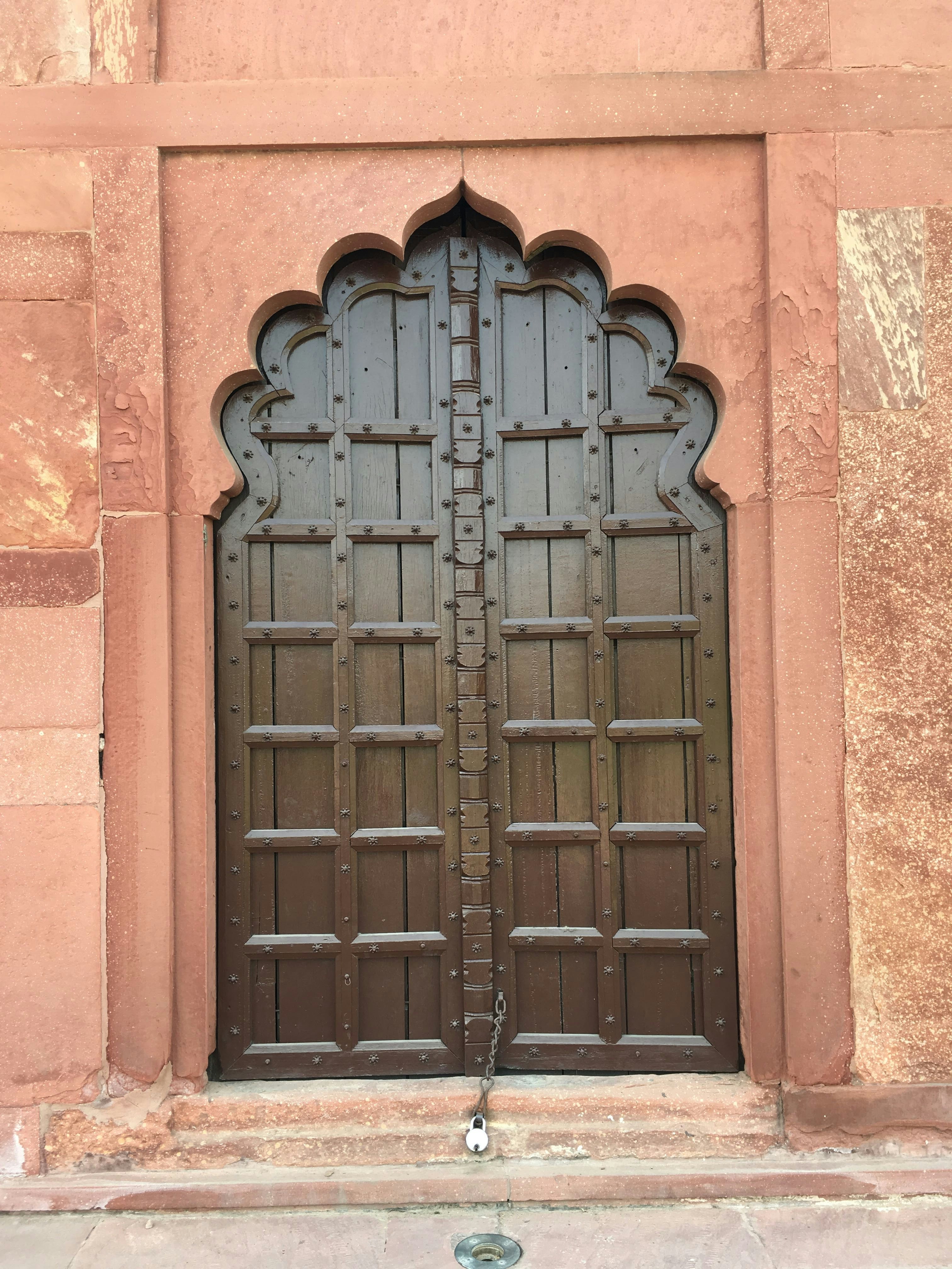 The doors of Agra Fort exhibit elaborate Mughal design, featuring intricate carvings and holding historical importance in the grand fortress architecture.