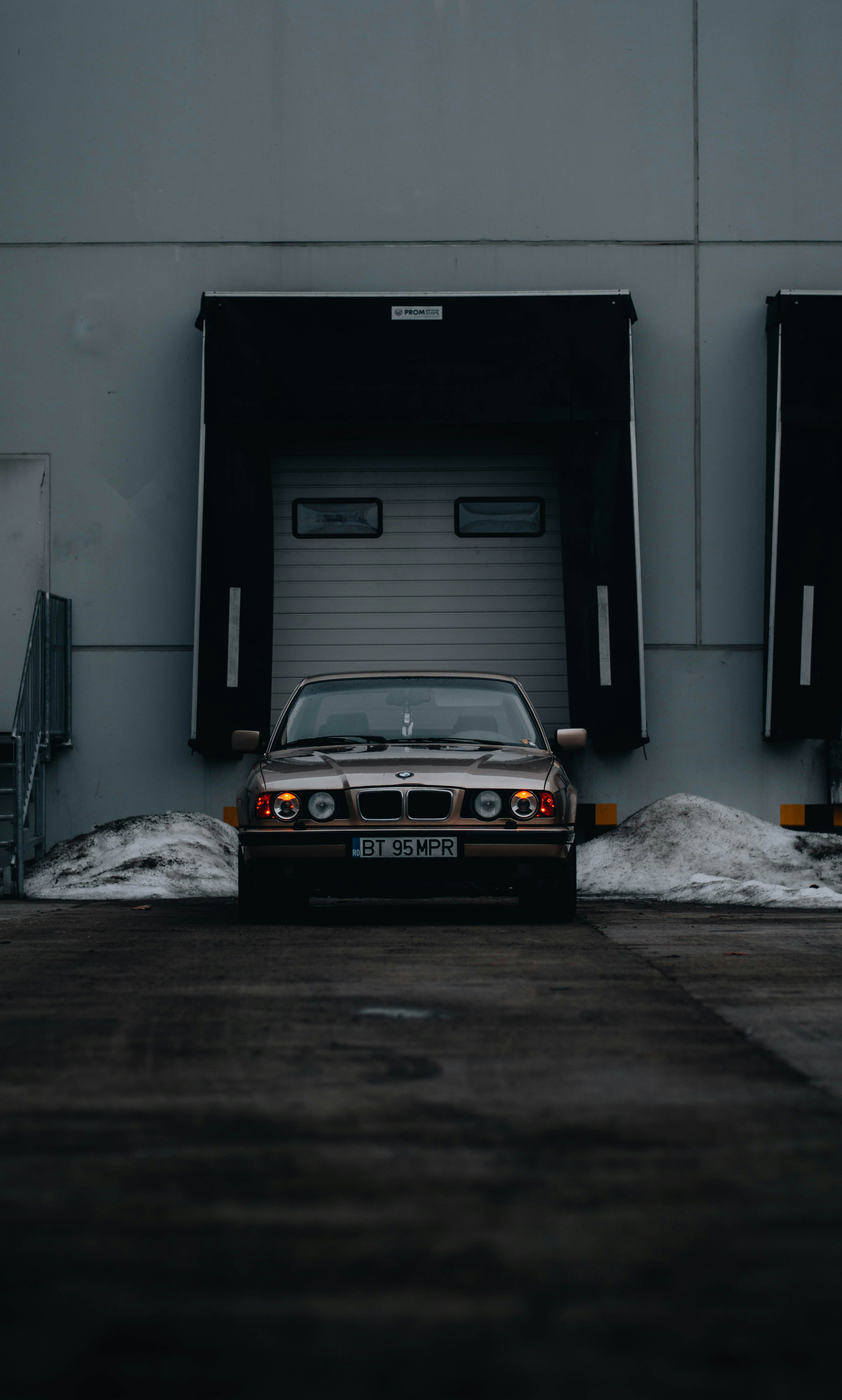 Midnight Dock: A Vintage BMW 3-Series Pauses at the Snowy Loading Bay