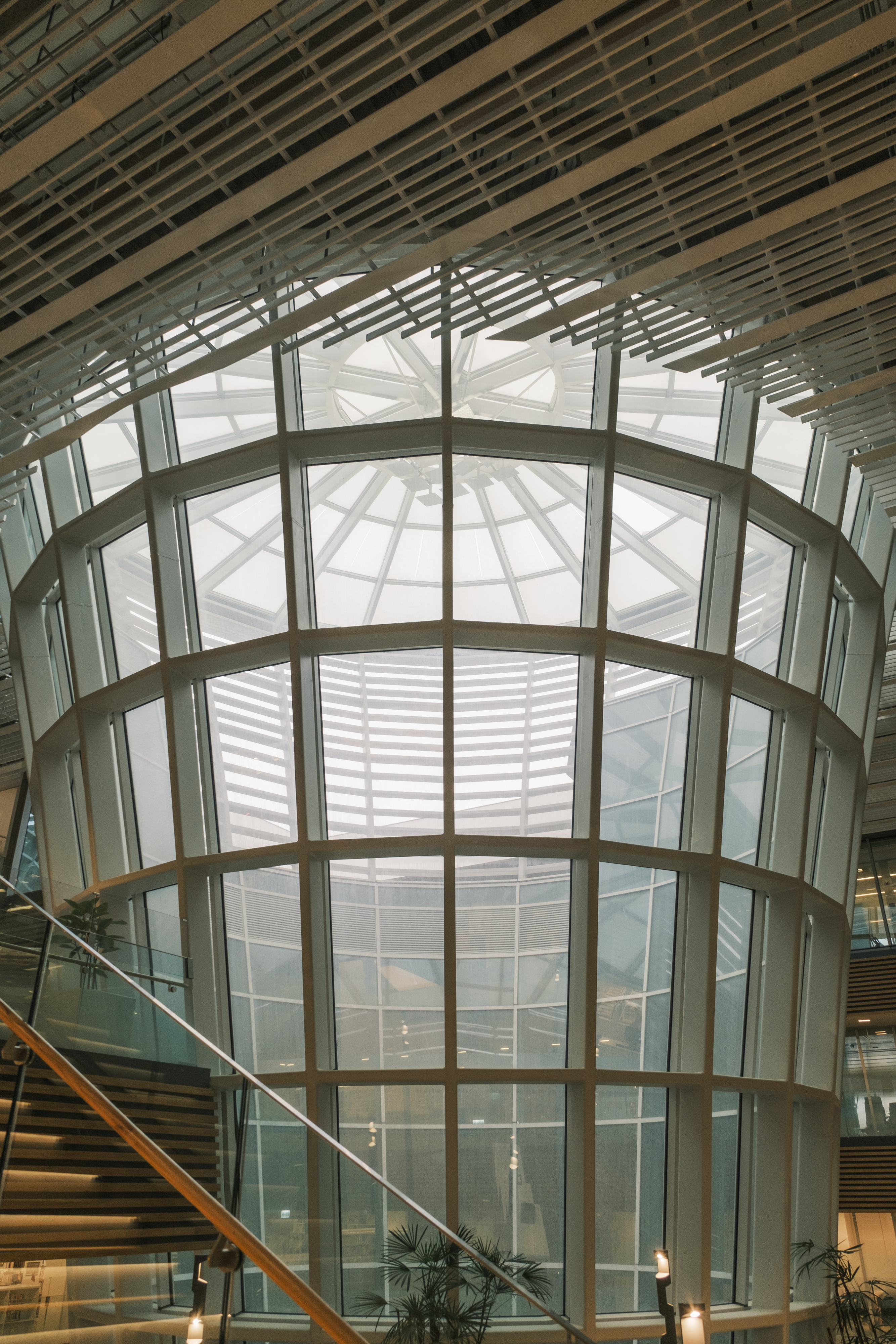A large atrium with a staircase and glass walls photo – Free Staircase ...