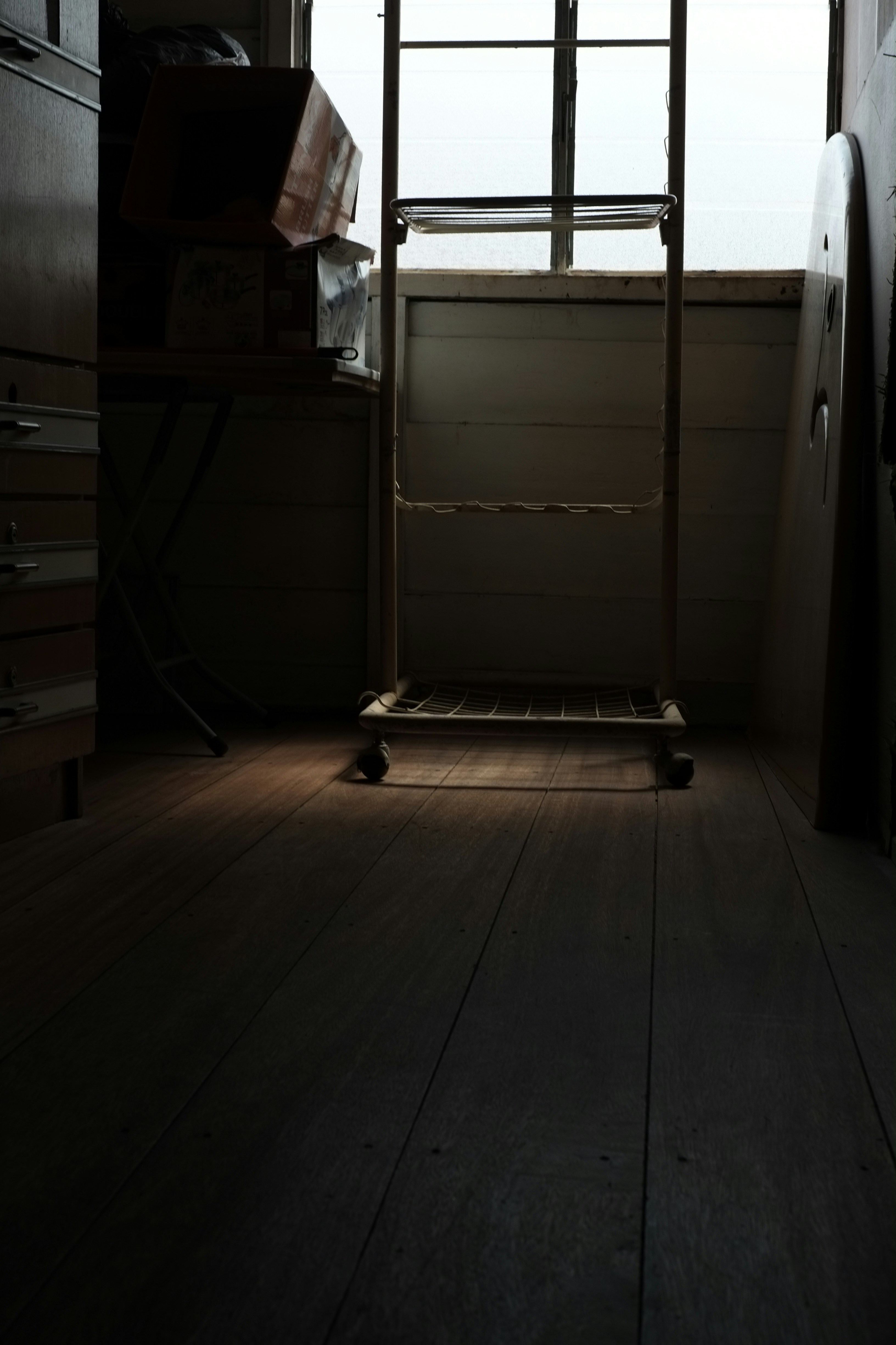 a dark room with a ladder leading to a window