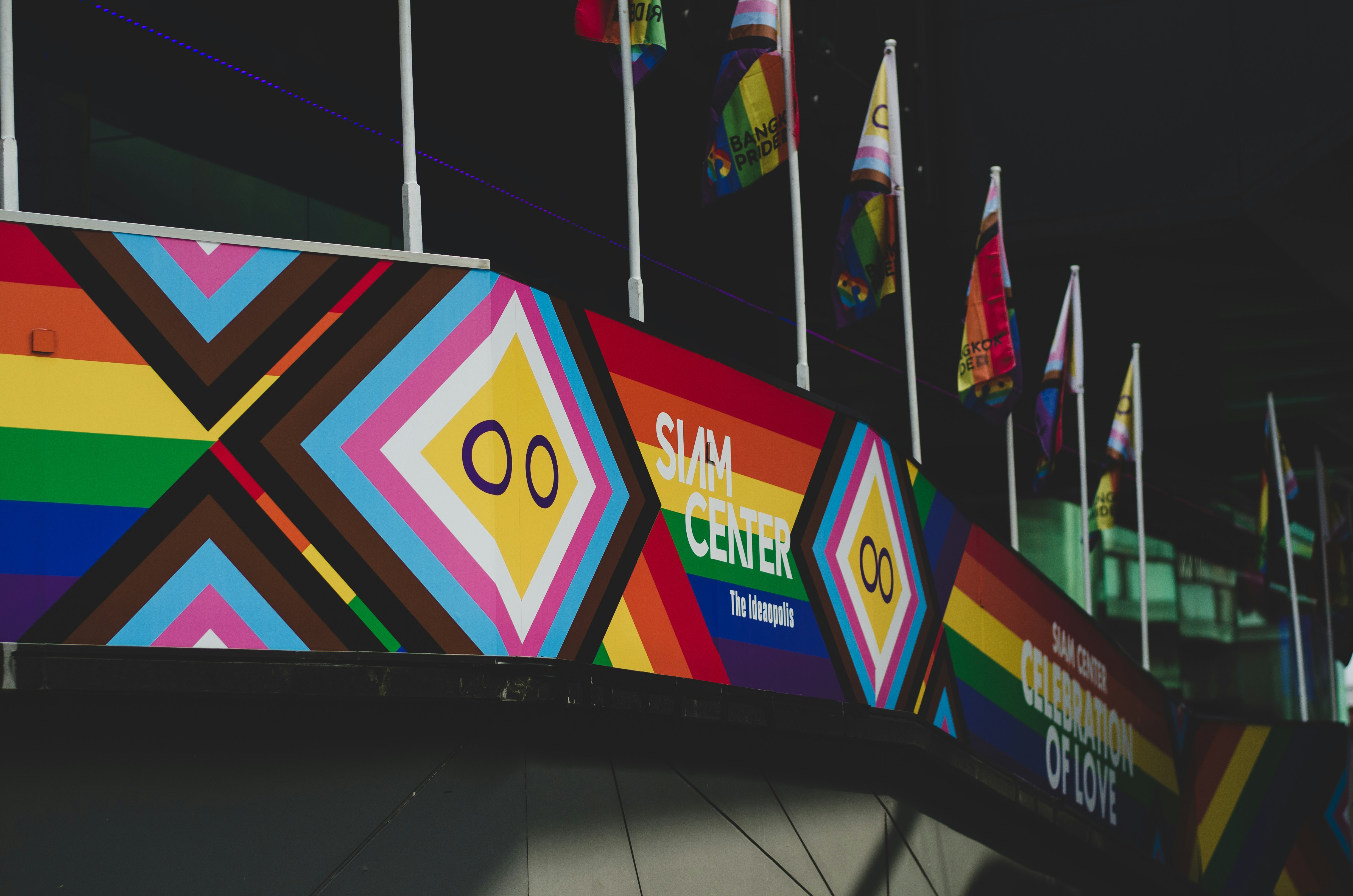 Kaleidoscopic Diamond Wall Over a Flag-Lined Plaza