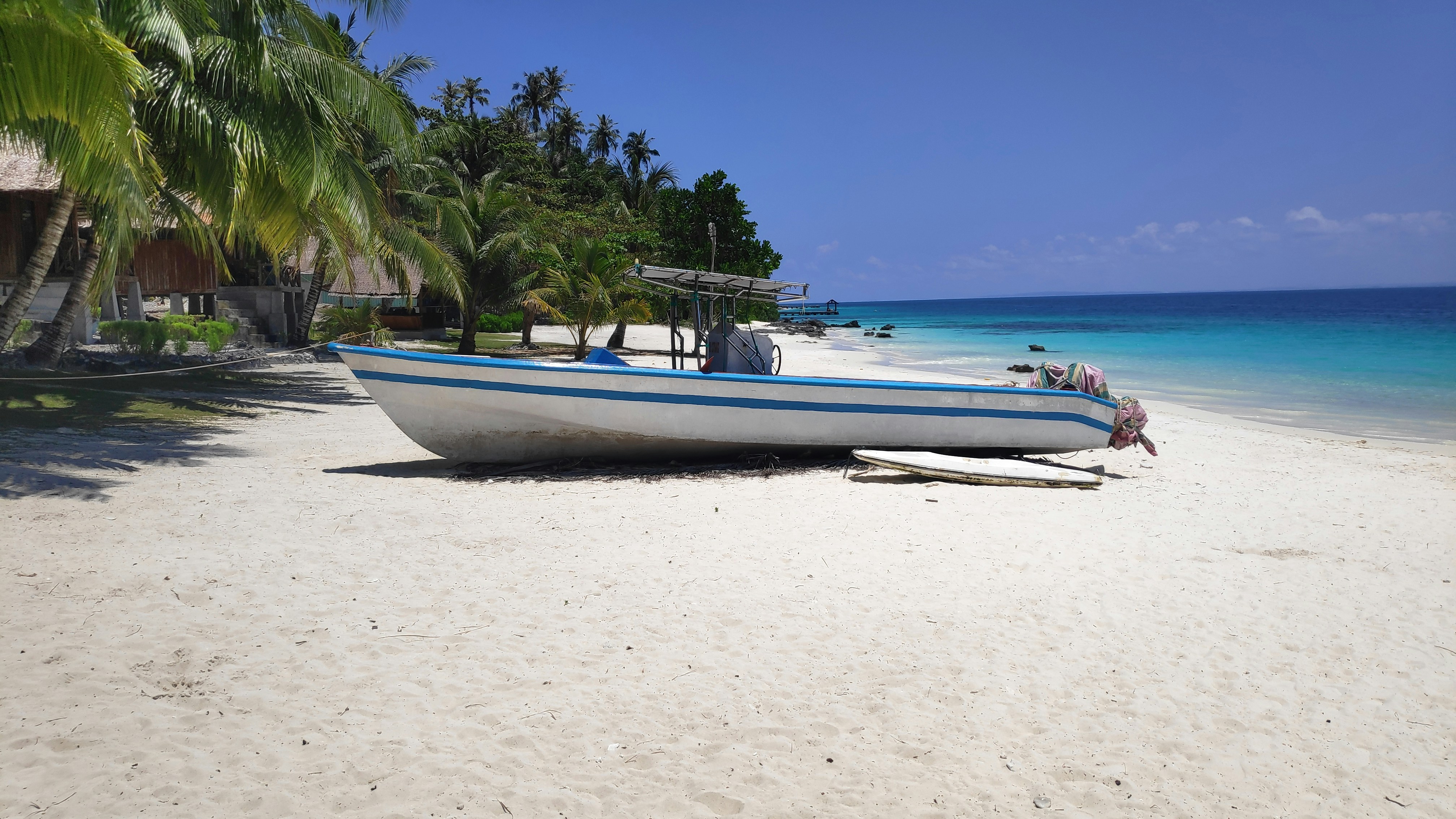 Lone Motorboat on Pristine Sand: A Quiet Tropical Vista