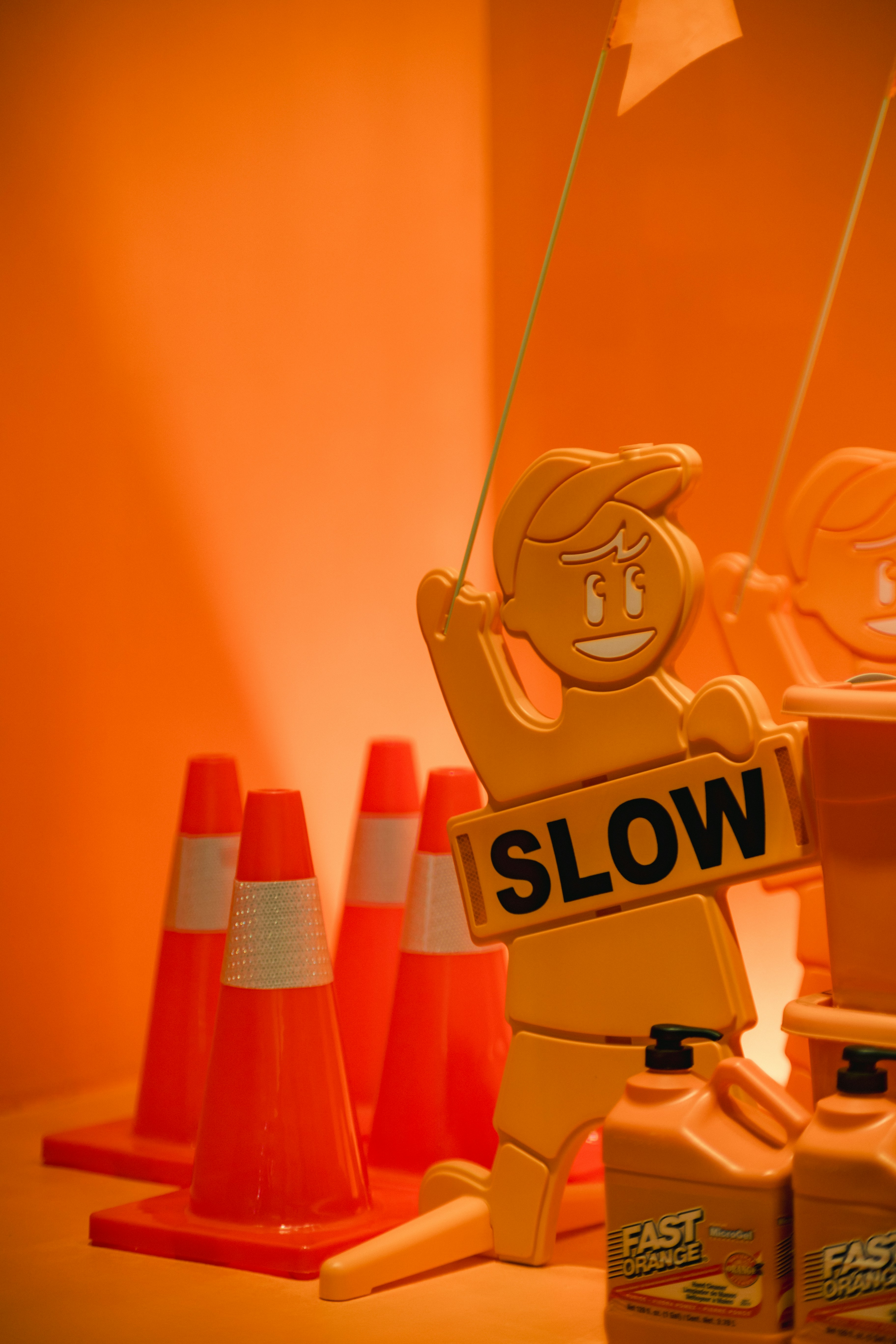 A toy figure holding a slow sign next to traffic cones photo – Free ...