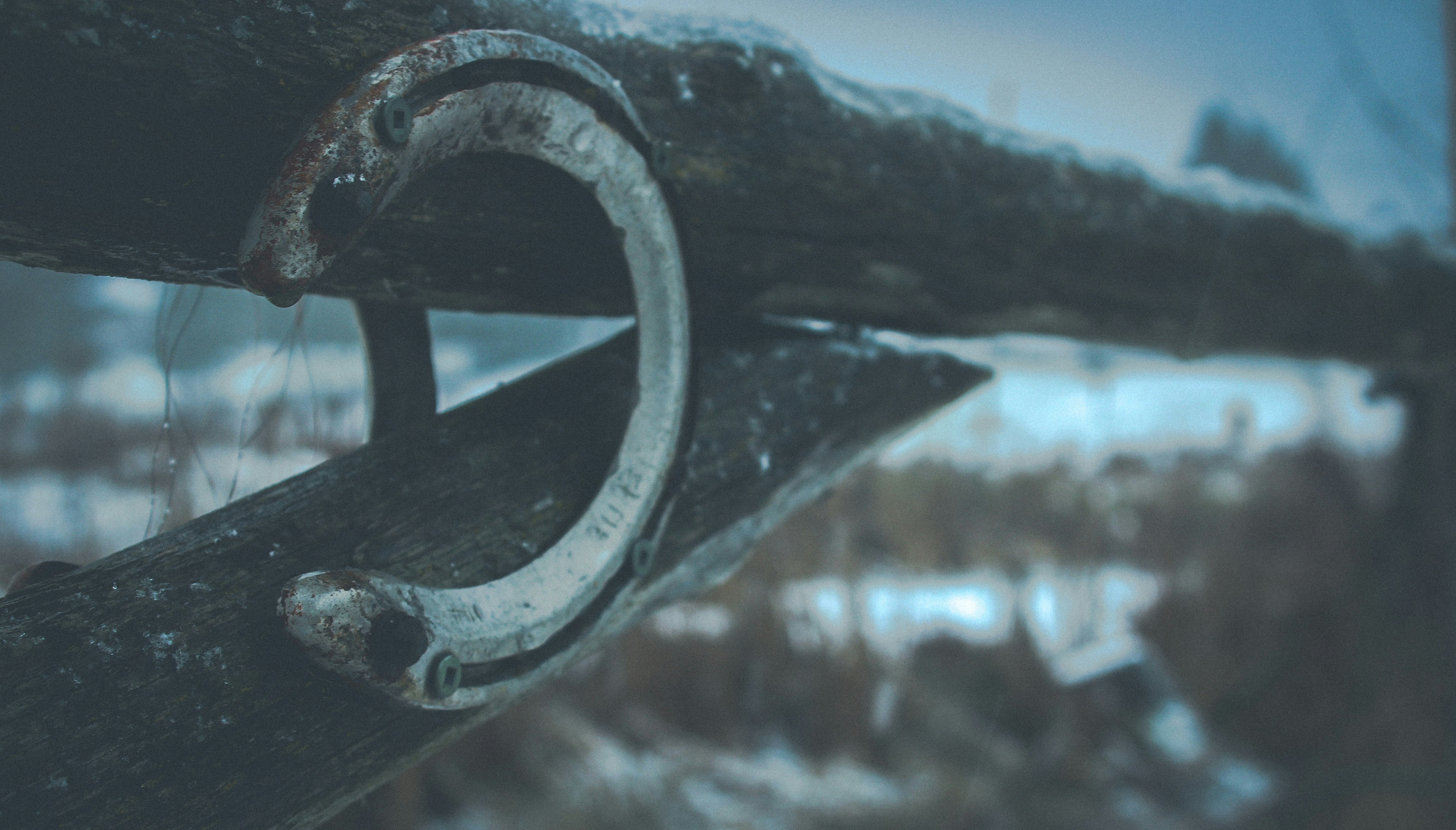 Winter-Frozen Hardware: close-up on a metal ring gripping weathered timber