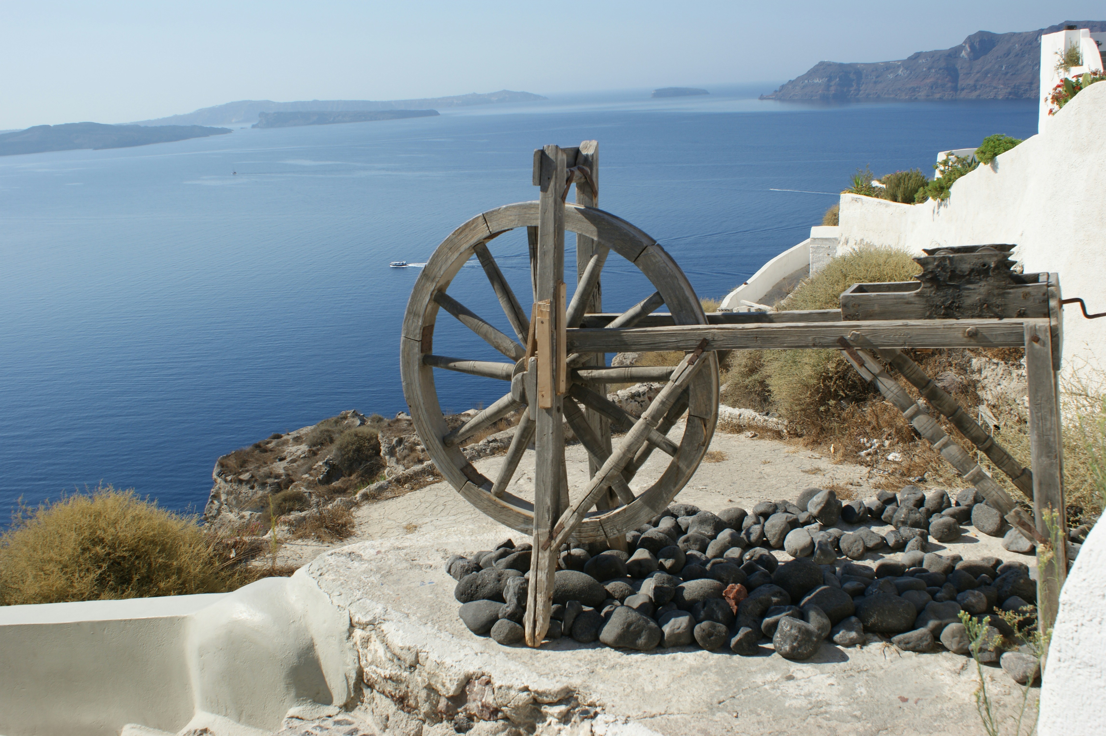 A water wheel sitting on top of a hill next to a body of water photo ...