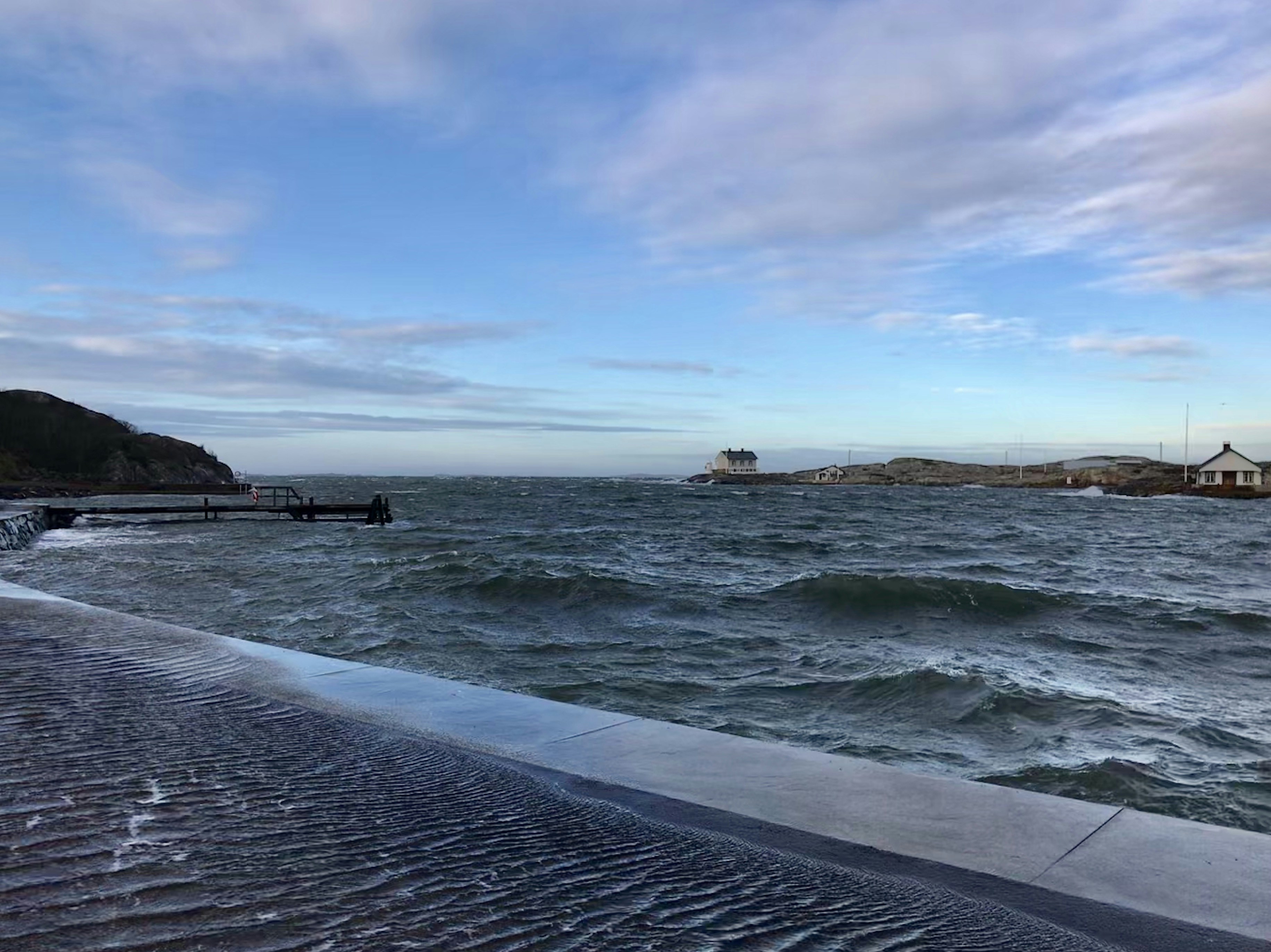 Distant Beacon over a Wind-Swept Seawall