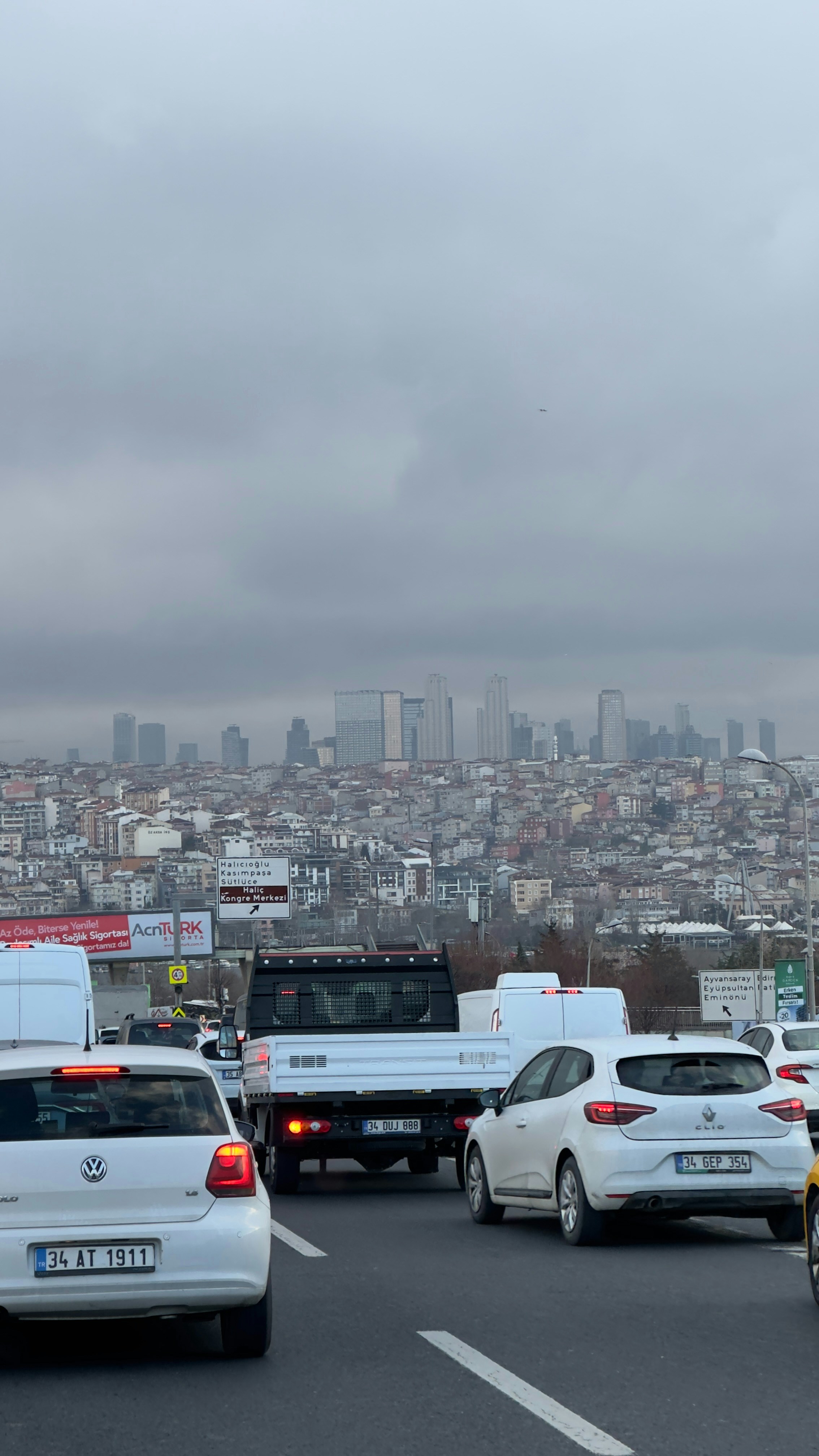 Rush Hour Horizon: Clouded Cityscape Beyond the Traffic