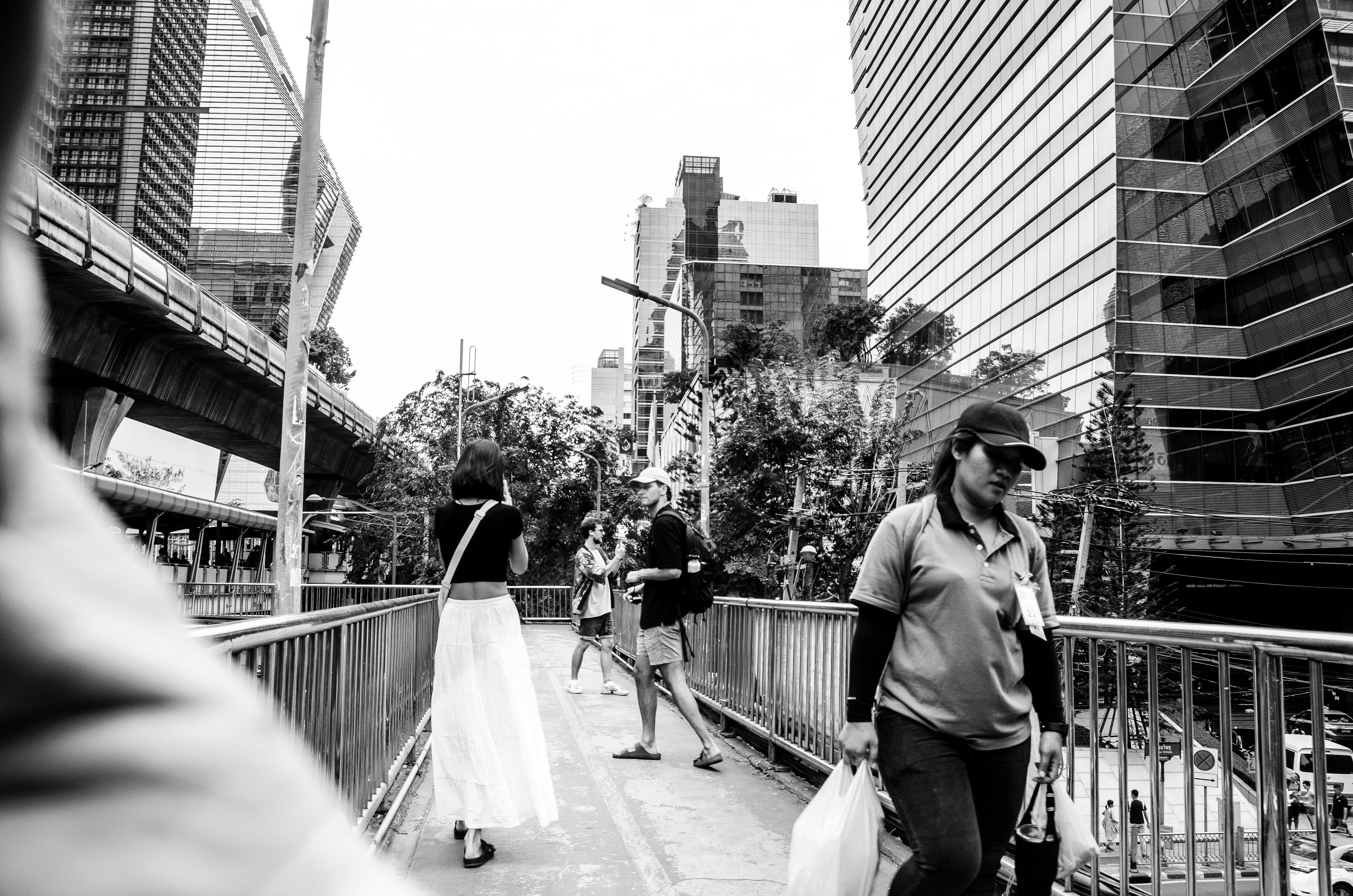 Faces in Transit on a Narrow City Skybridge