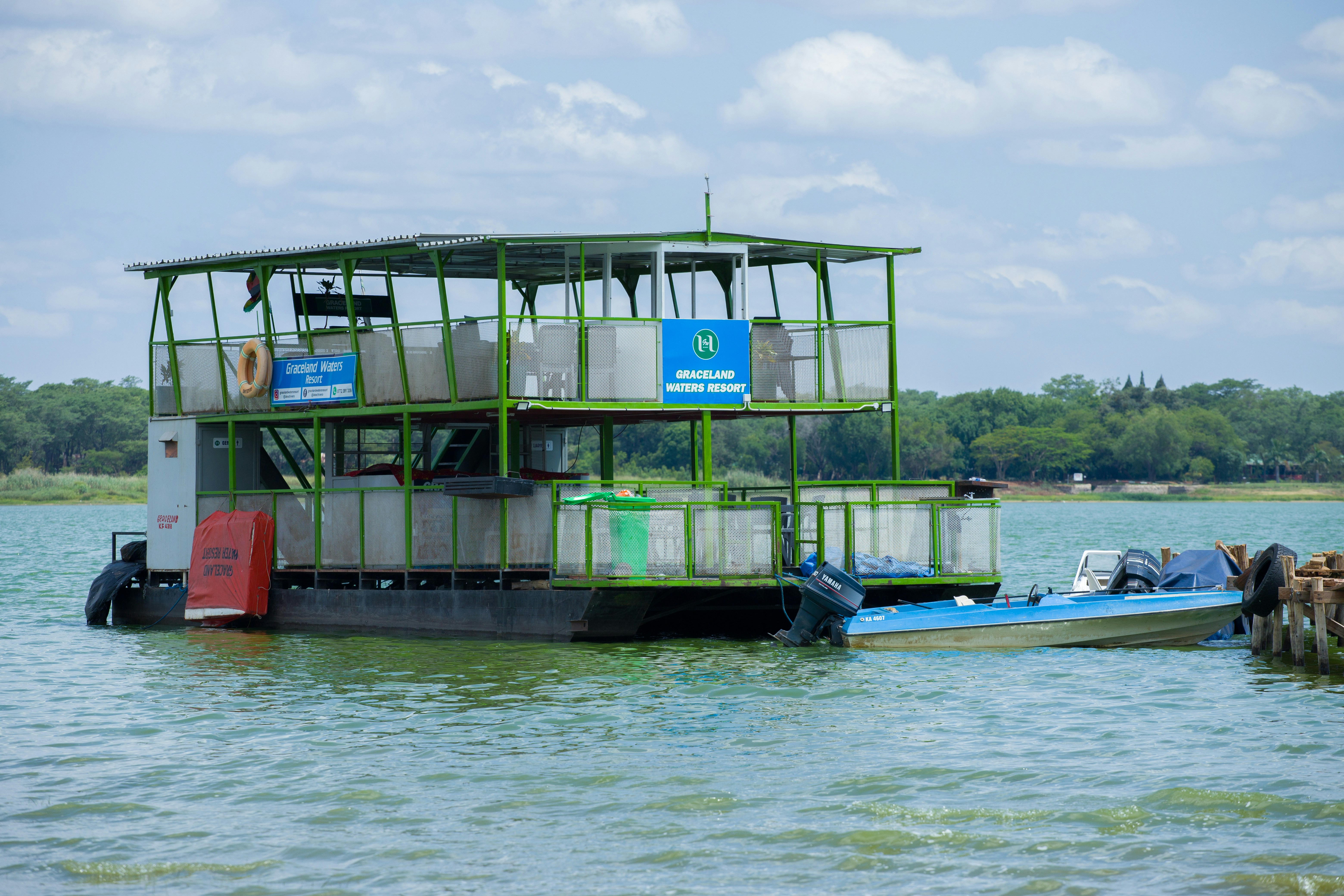 Emerald Deck: Green-Frame River Ferry Moored on Calm Waters