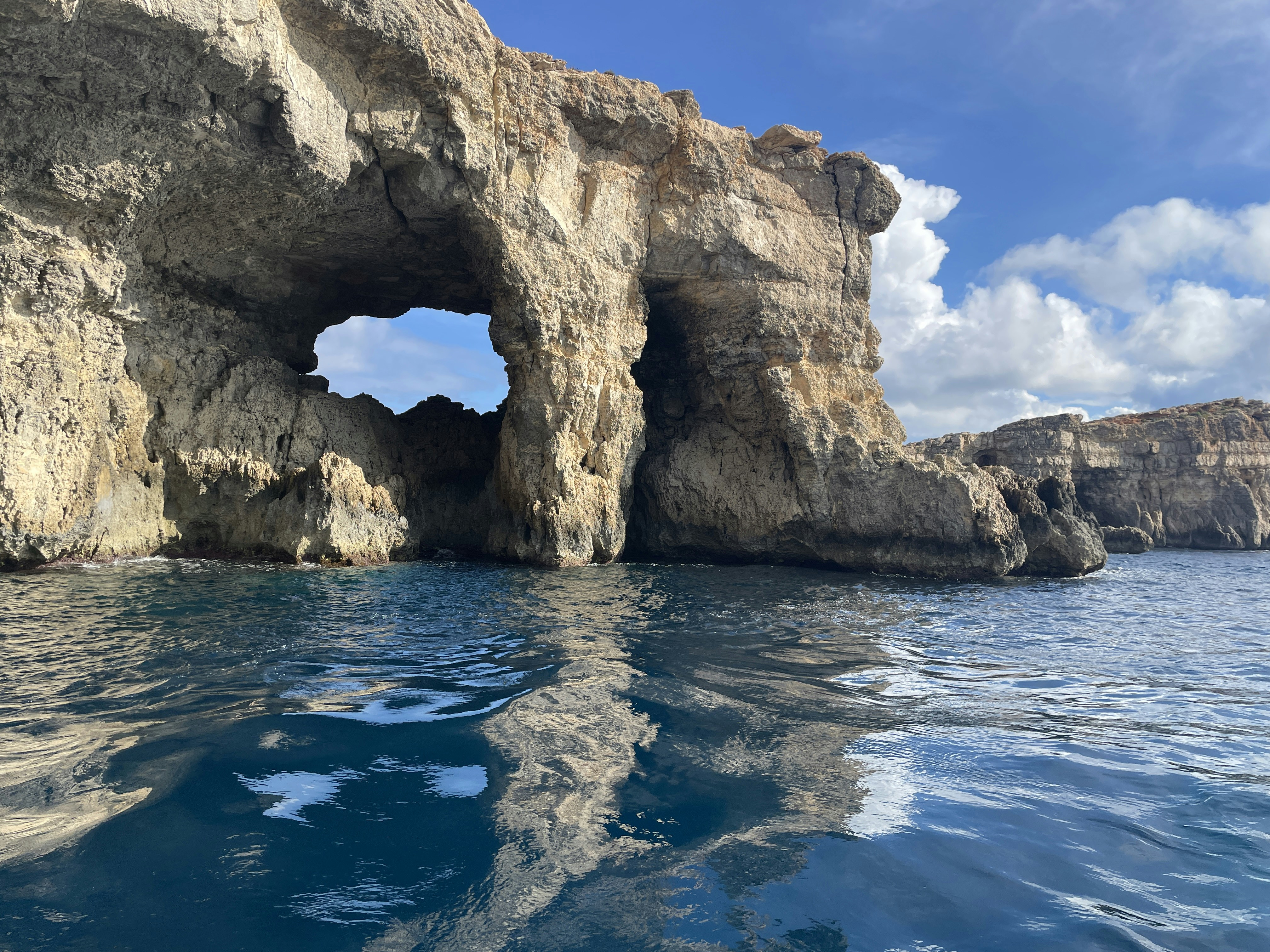 Arch of the Sea Gate: Carved Limestone Opening over Calm Blue Water