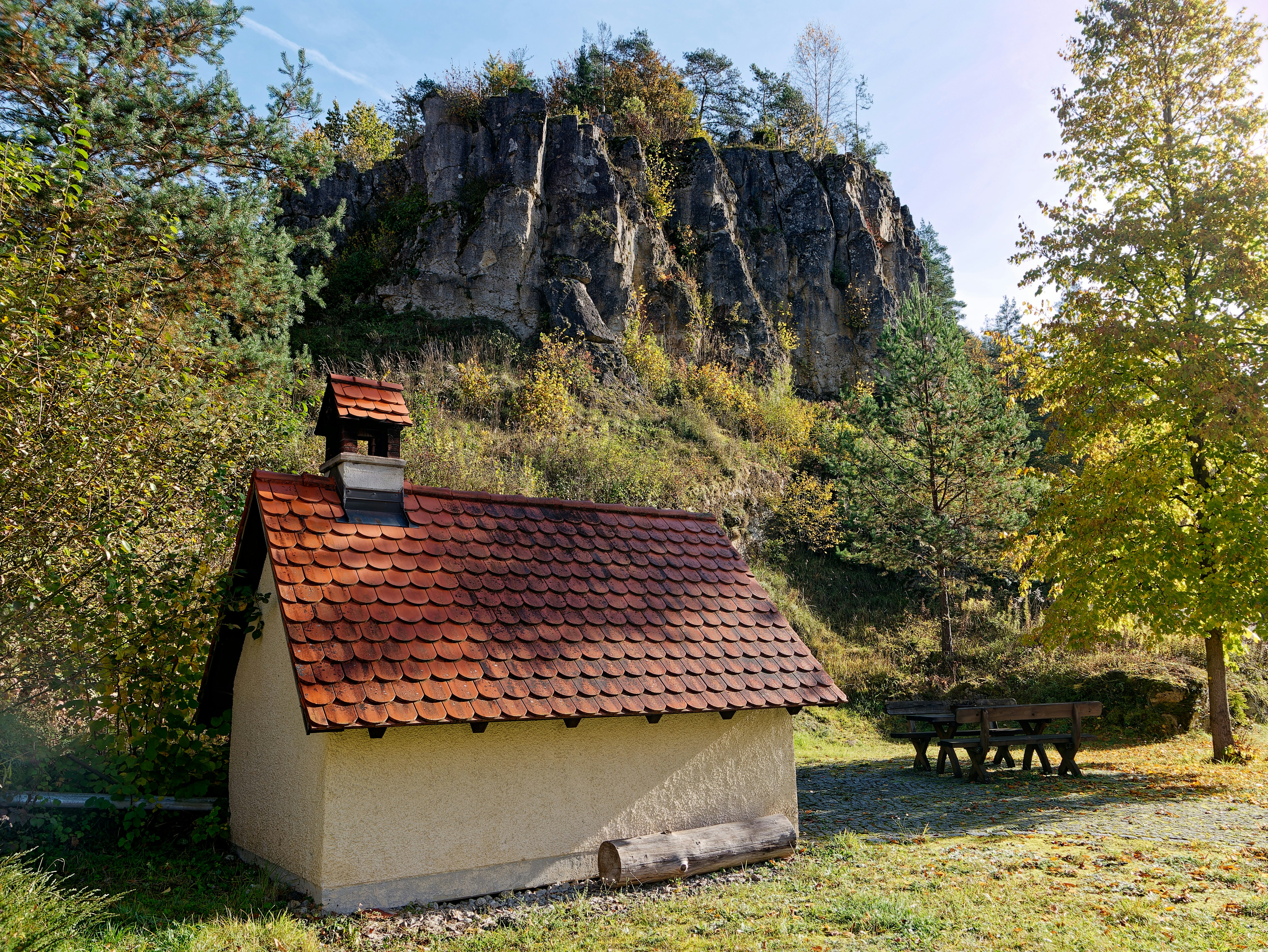 Sunlit Hut by a Rugged Cliff: A Quiet Countryside Refuge