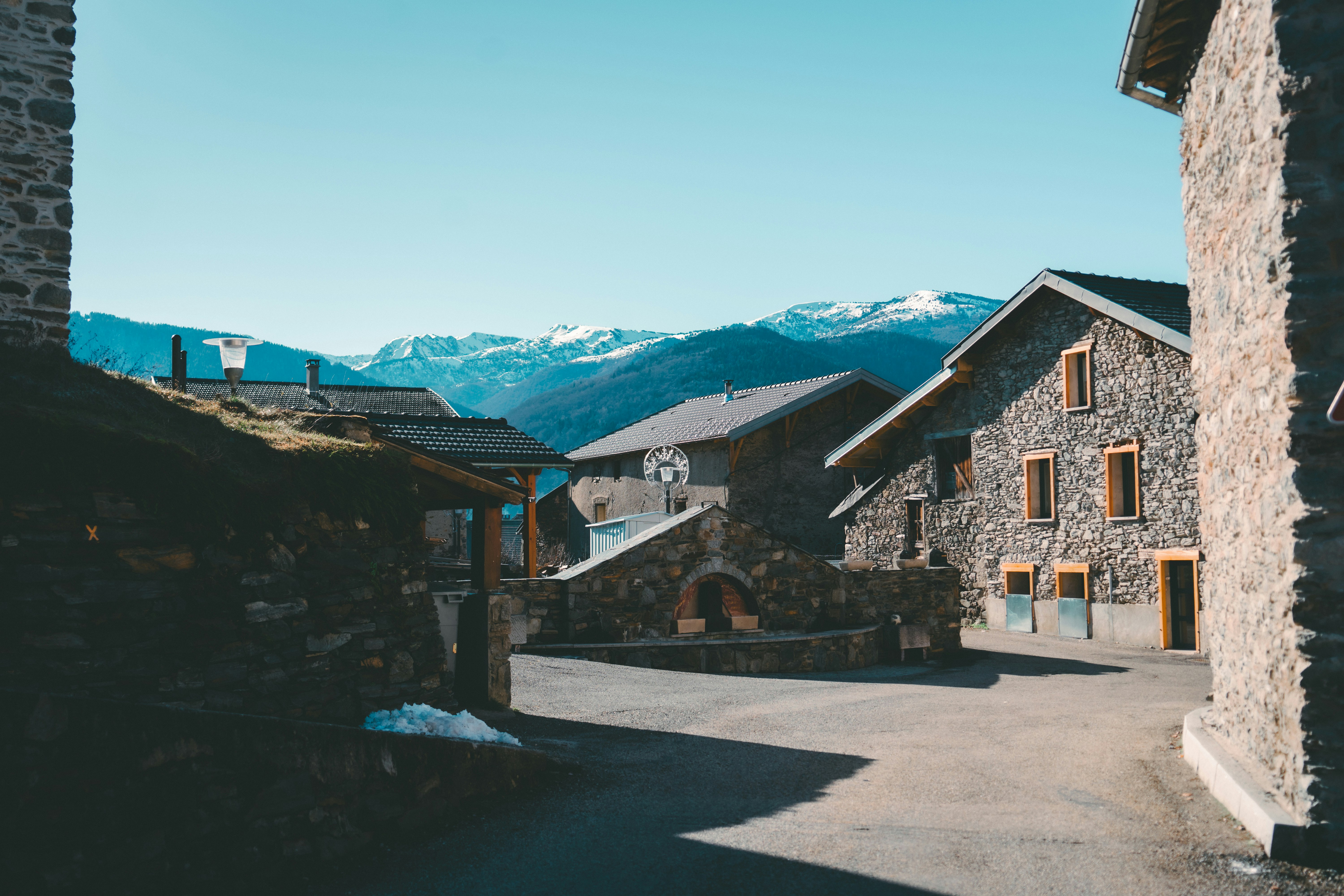 Stone-Arched Lane Framing Snow-Capped Peaks Under Clear Alpine Sky