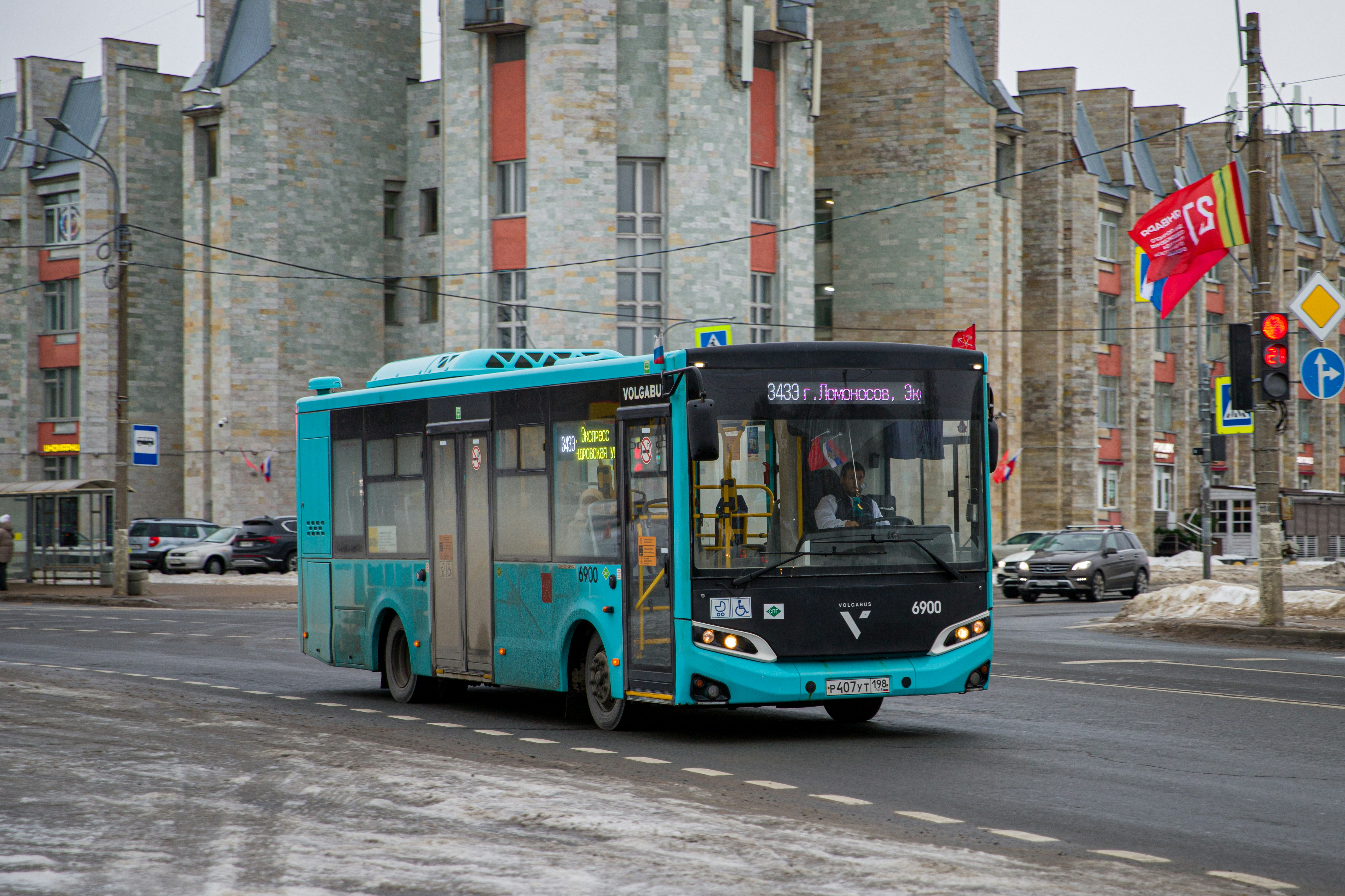 A blue bus driving down a street next to tall buildings photo – Free ...