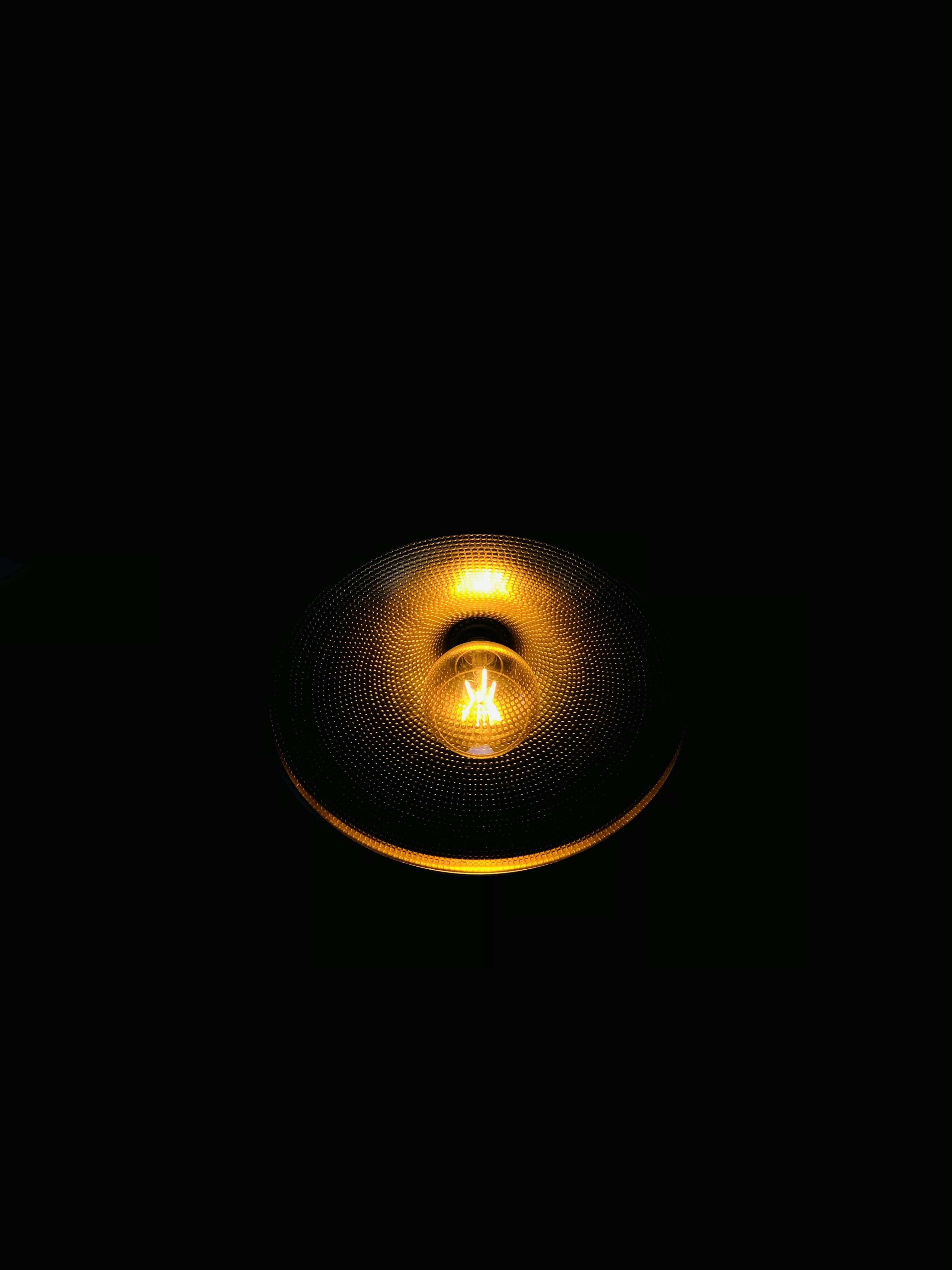 Amber Halo: A solitary bulb glows in the void