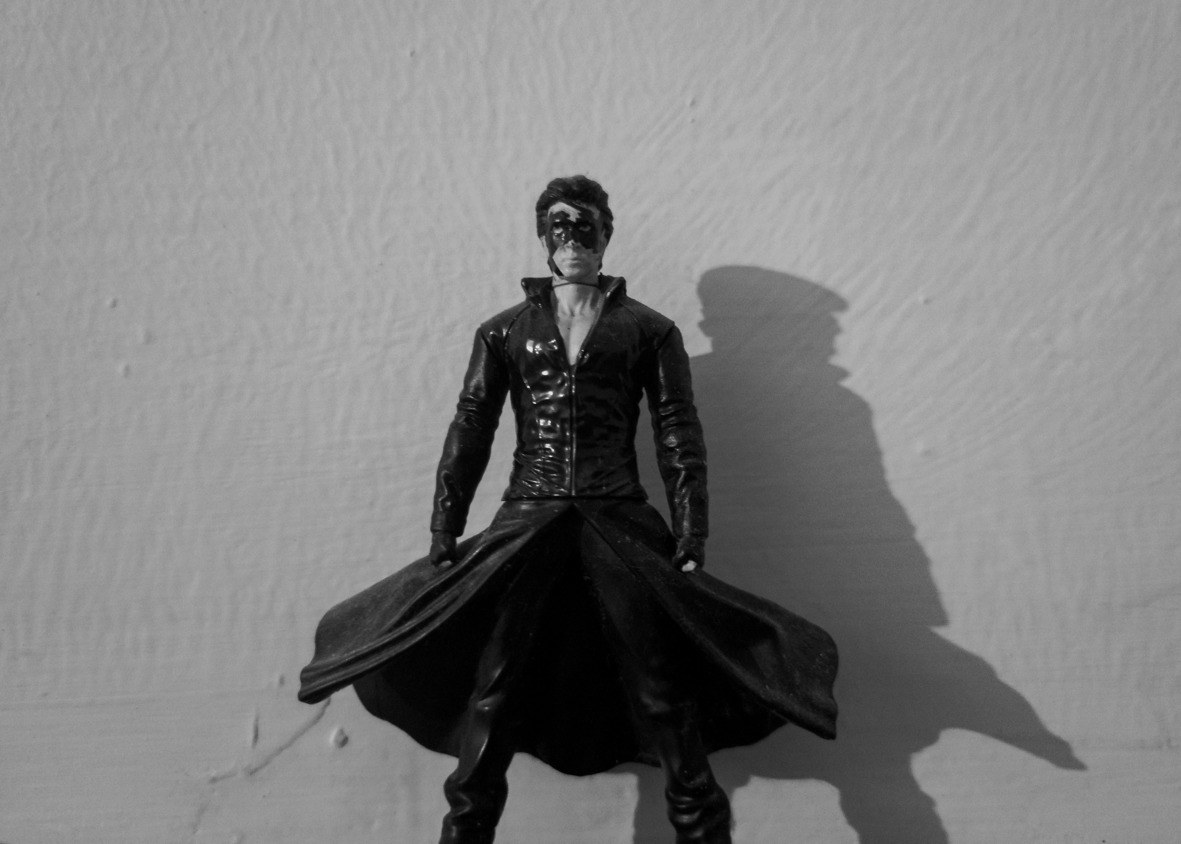 Monochrome Standoff: The Cape-Wearing Figure and Its Shadow