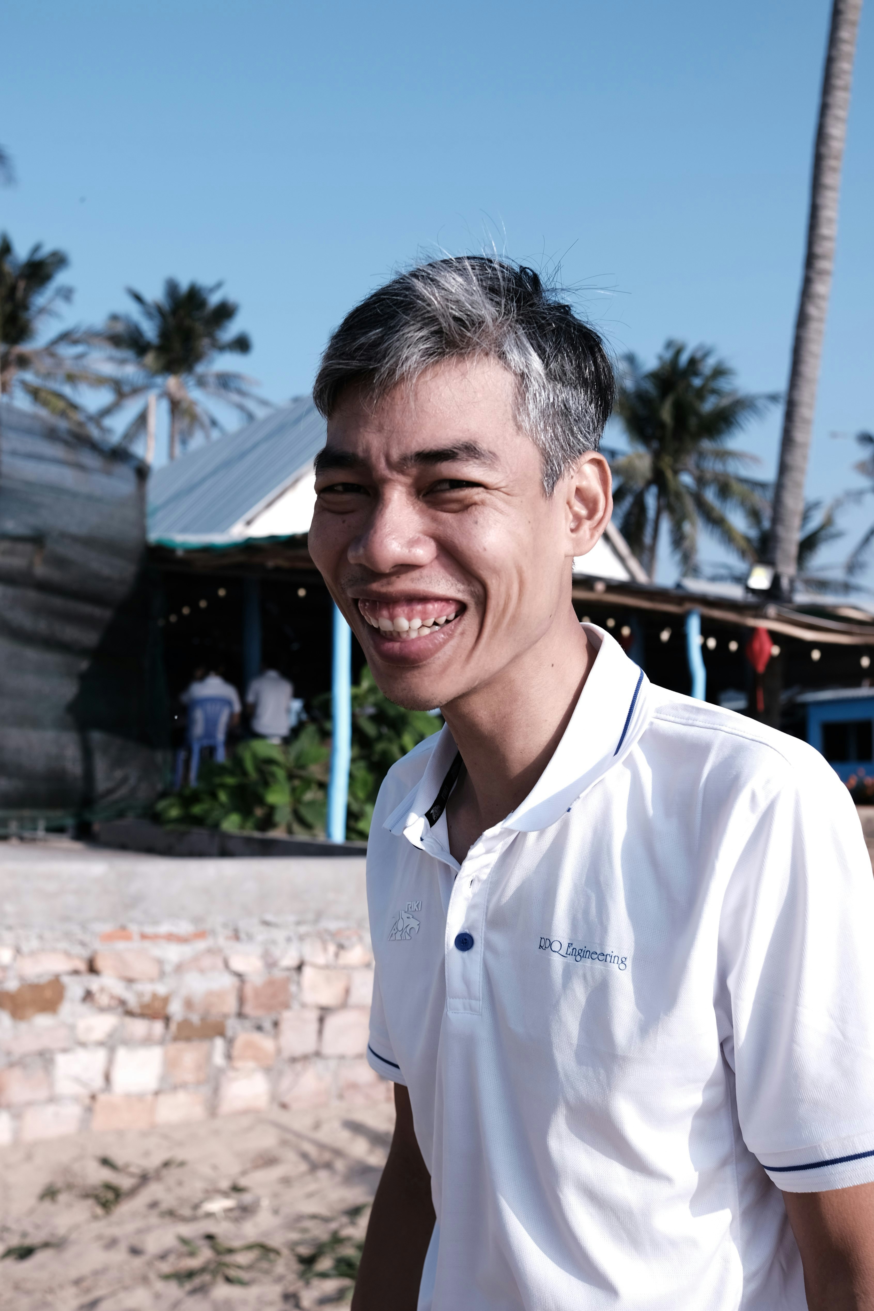 a man standing in front of a palm tree