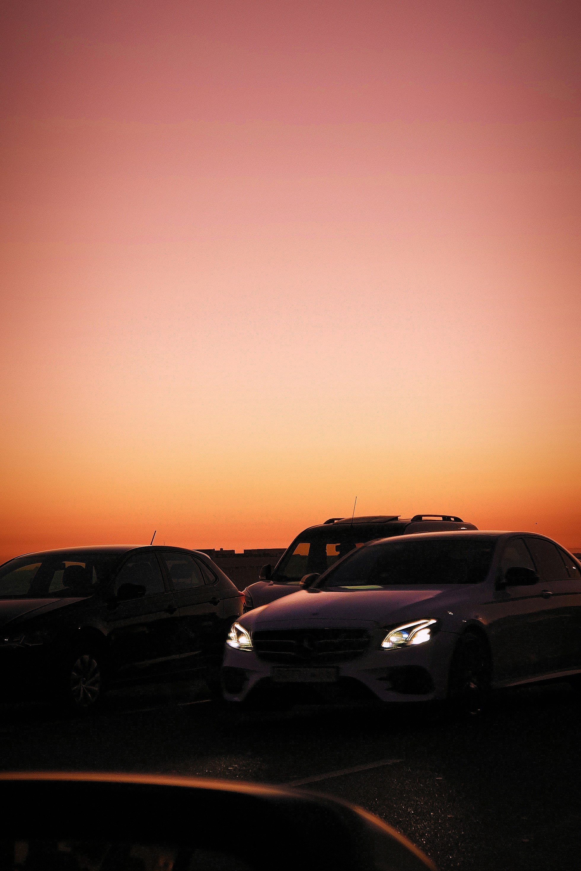 Horizon in Chrome: Sunset Framed by Parked Cars