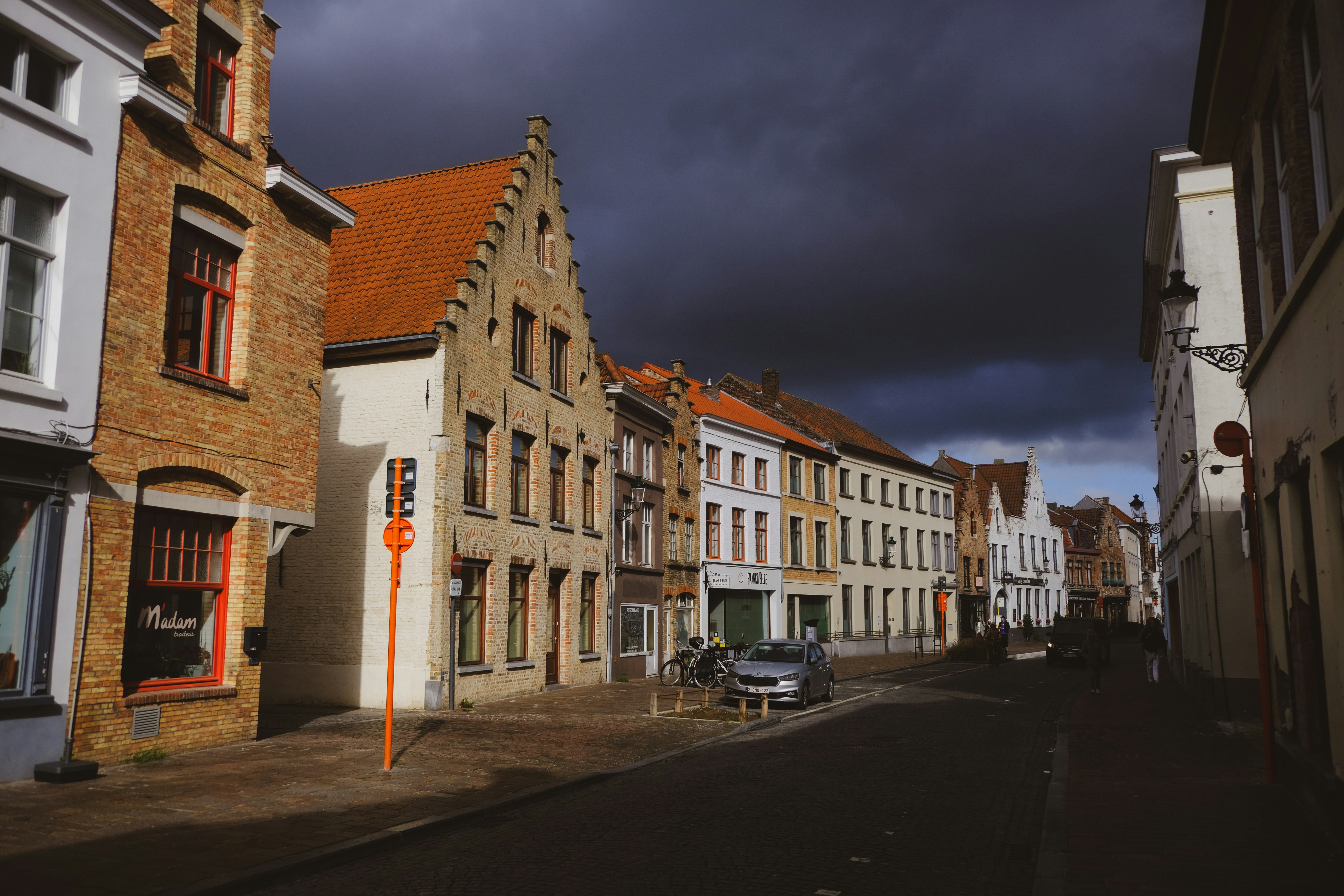 Stormy Sky Over a Flemish Street of Brick Townhouses