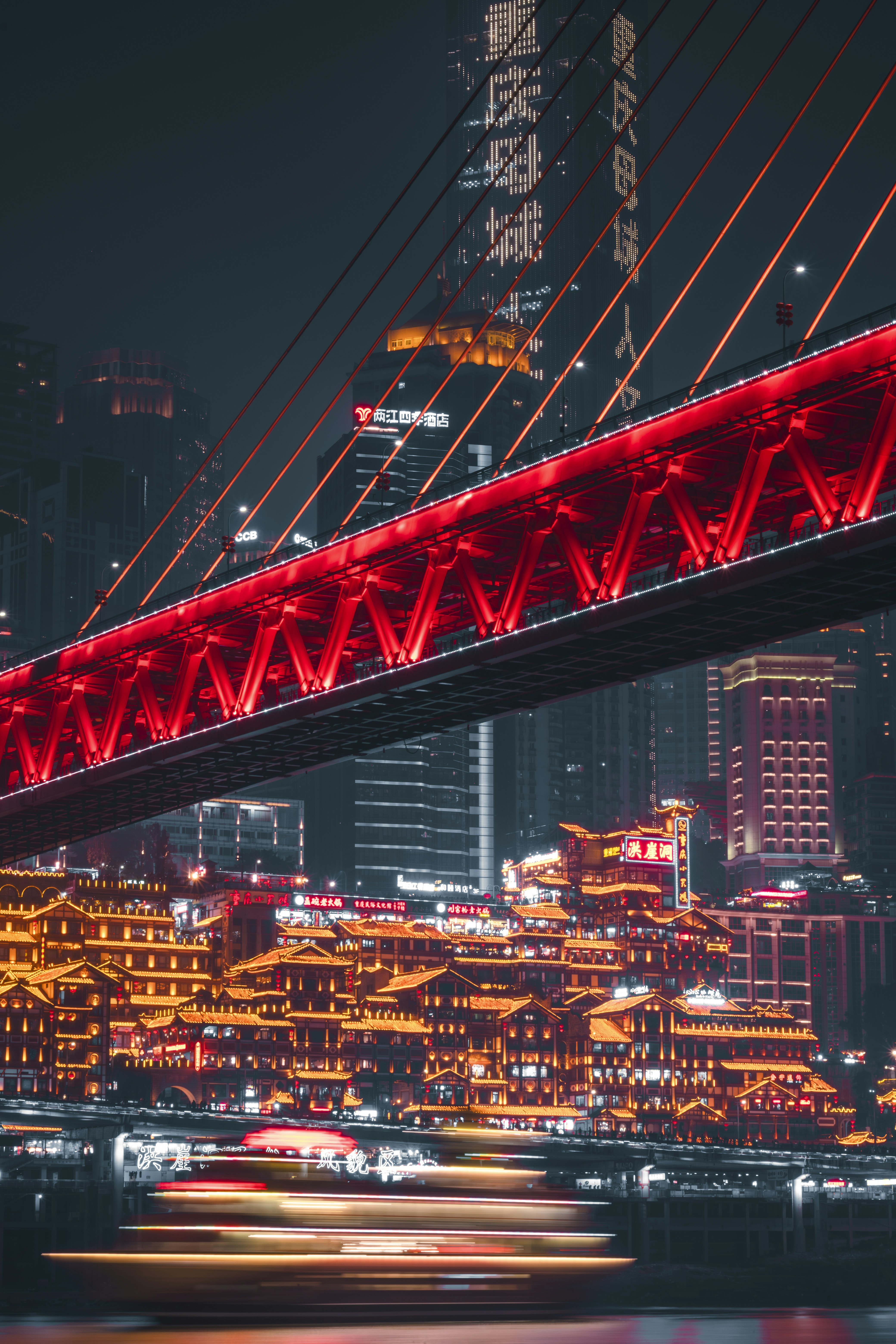 A red bridge over a river with a city in the background photo – Free ...