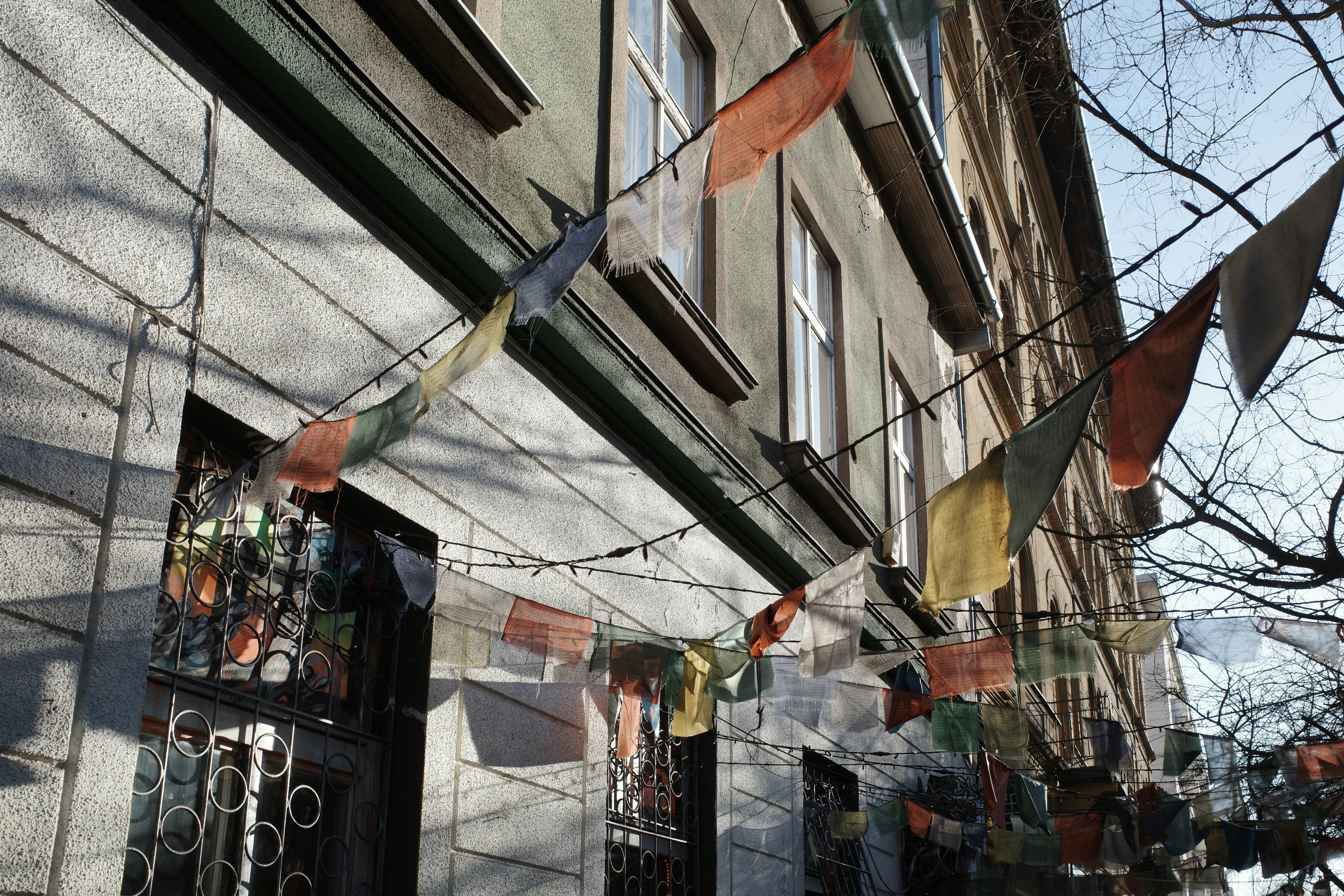 A building with a bunch of flags hanging from it's side photo – Free ...