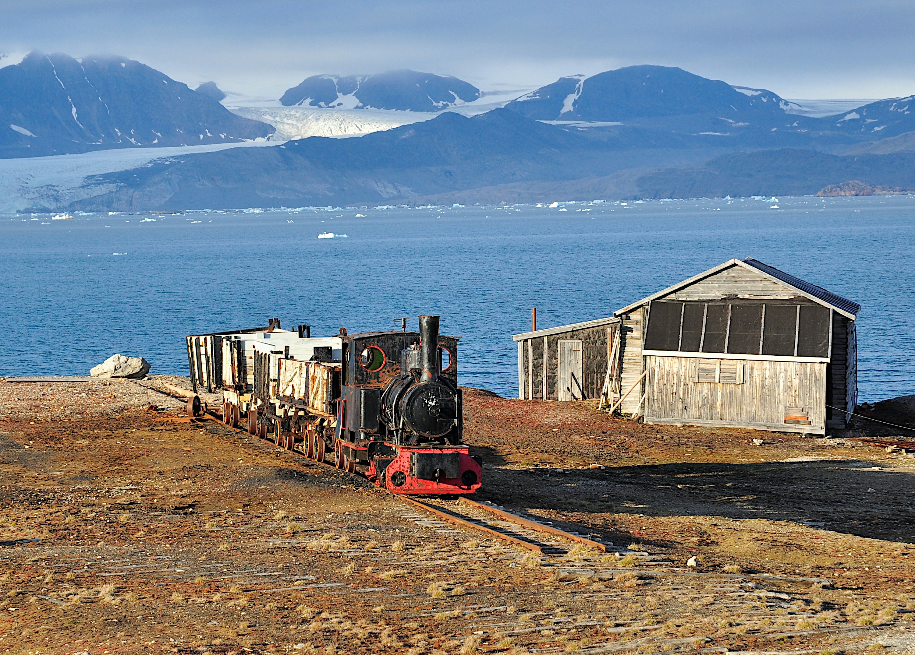 Old Narrow-Gauge Locomotive Resting by a Glacier-Bordered Shore