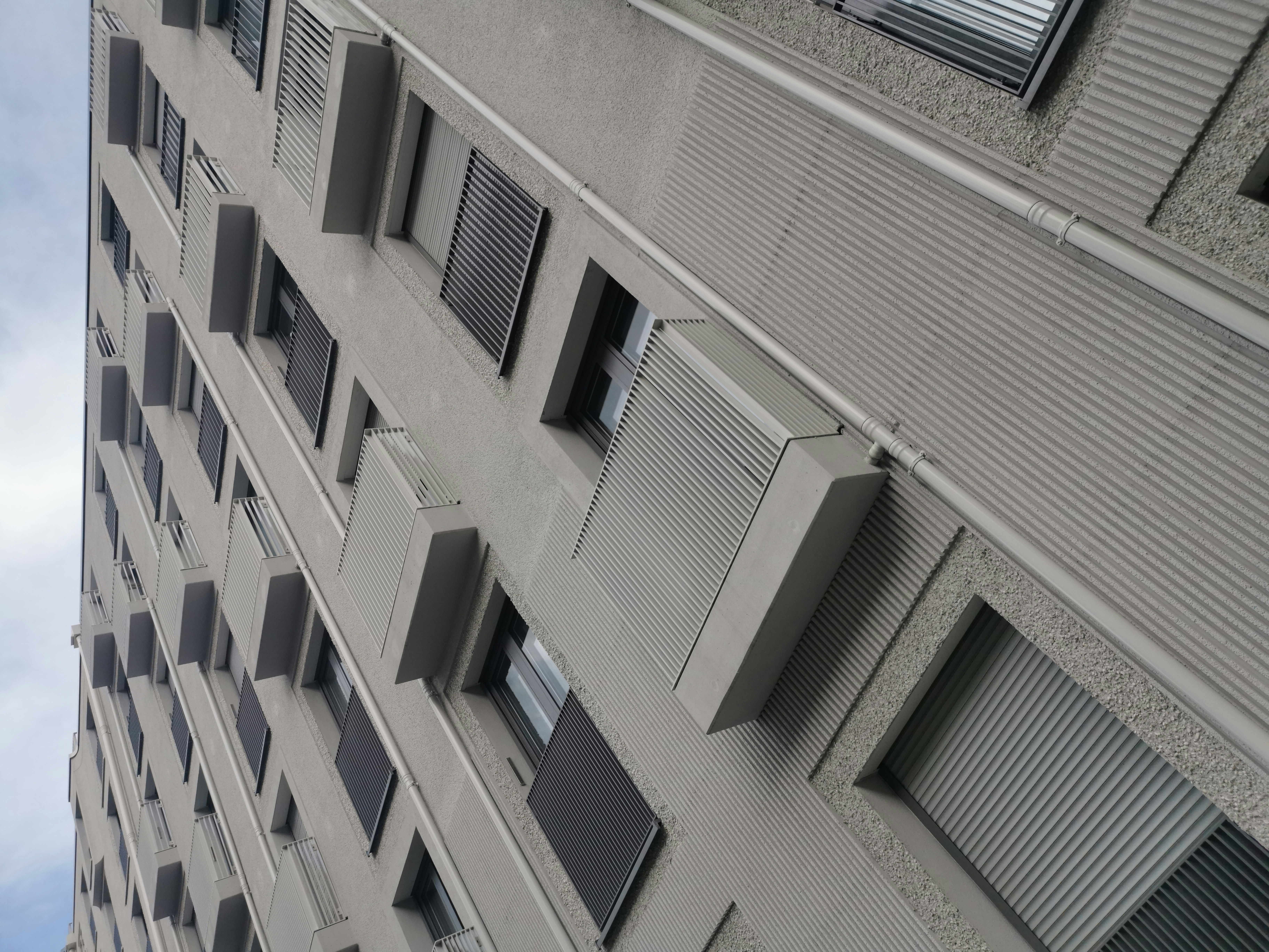 A tall building with many windows and shutters photo – Free ...