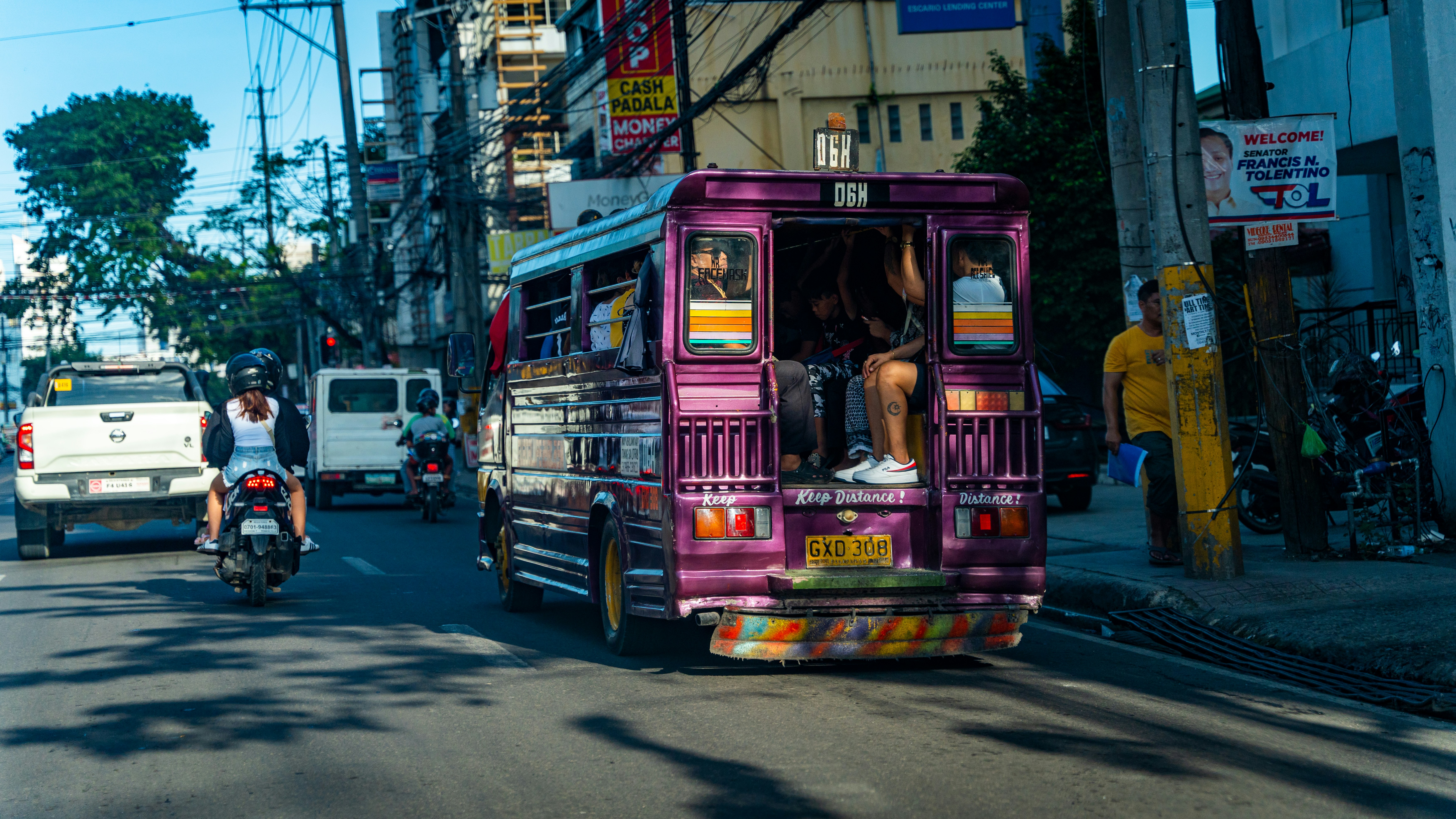 A purple bus driving down a street next to traffic photo – Free Cebu ...