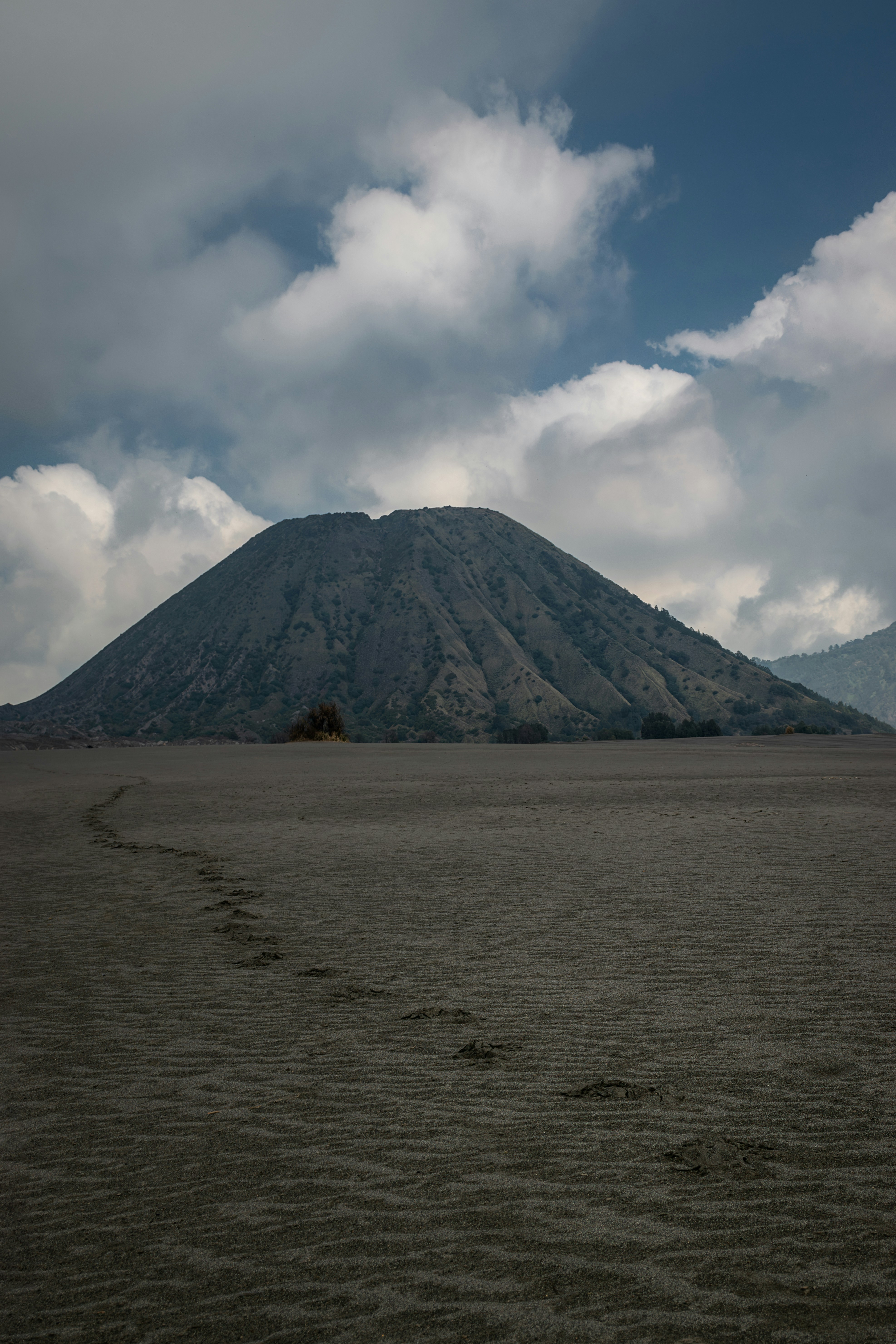 A large mountain in the distance with a trail in the foreground photo ...