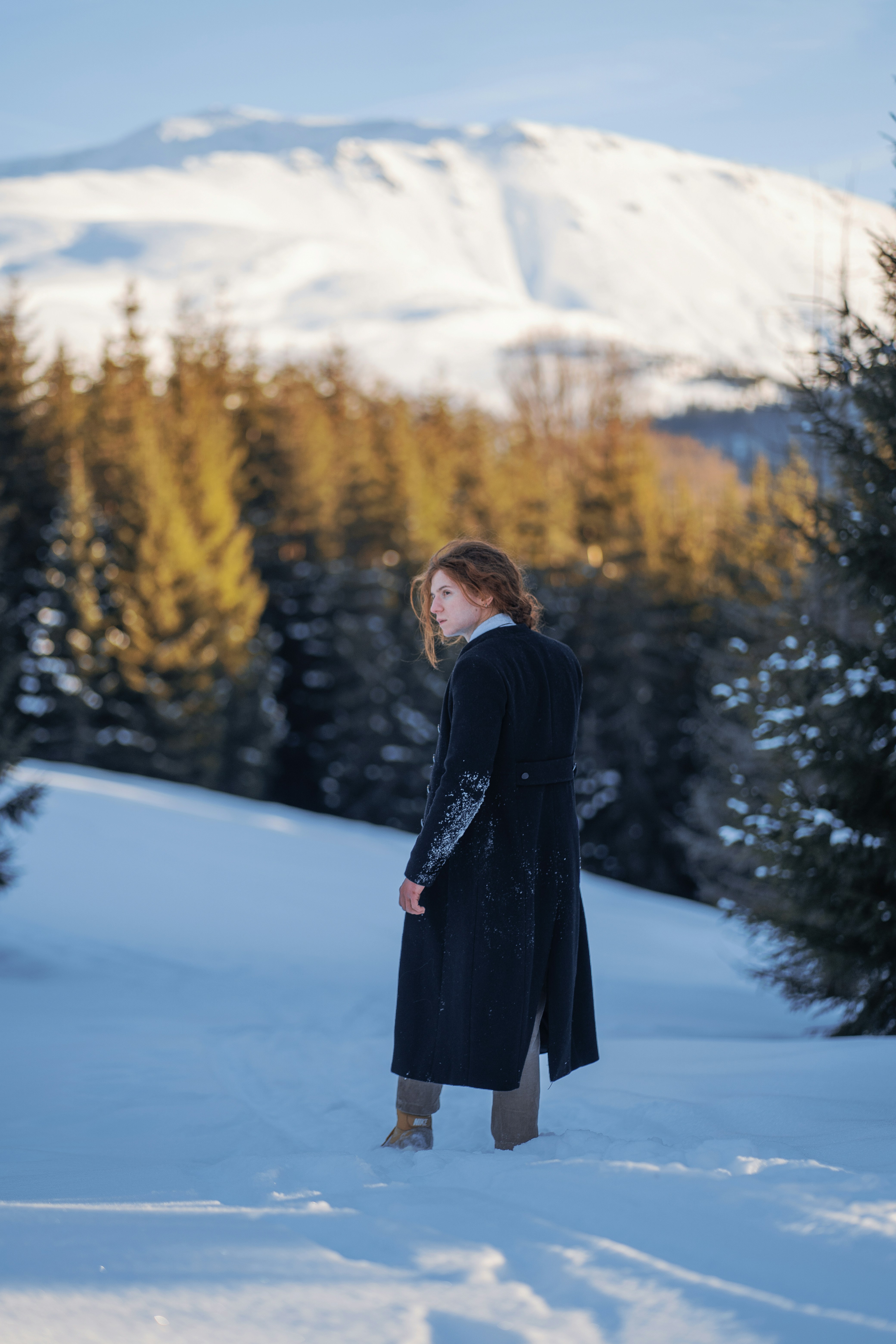 Winter Quiet: Portrait on a Snowfield Beneath a Snow-Capped Peak