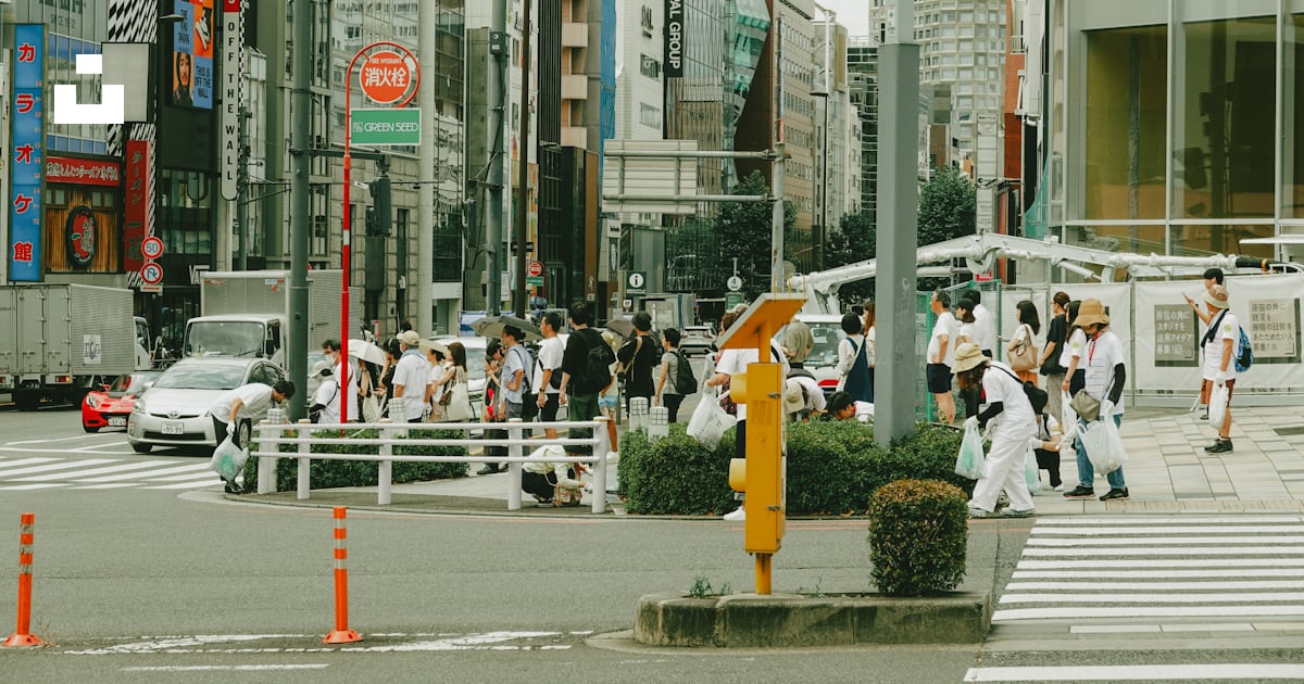 고층 건물 옆 길을 가로질러 걷고 있는 한 무리의 사람들 사진 Unsplash의 무료 자동차 이미지