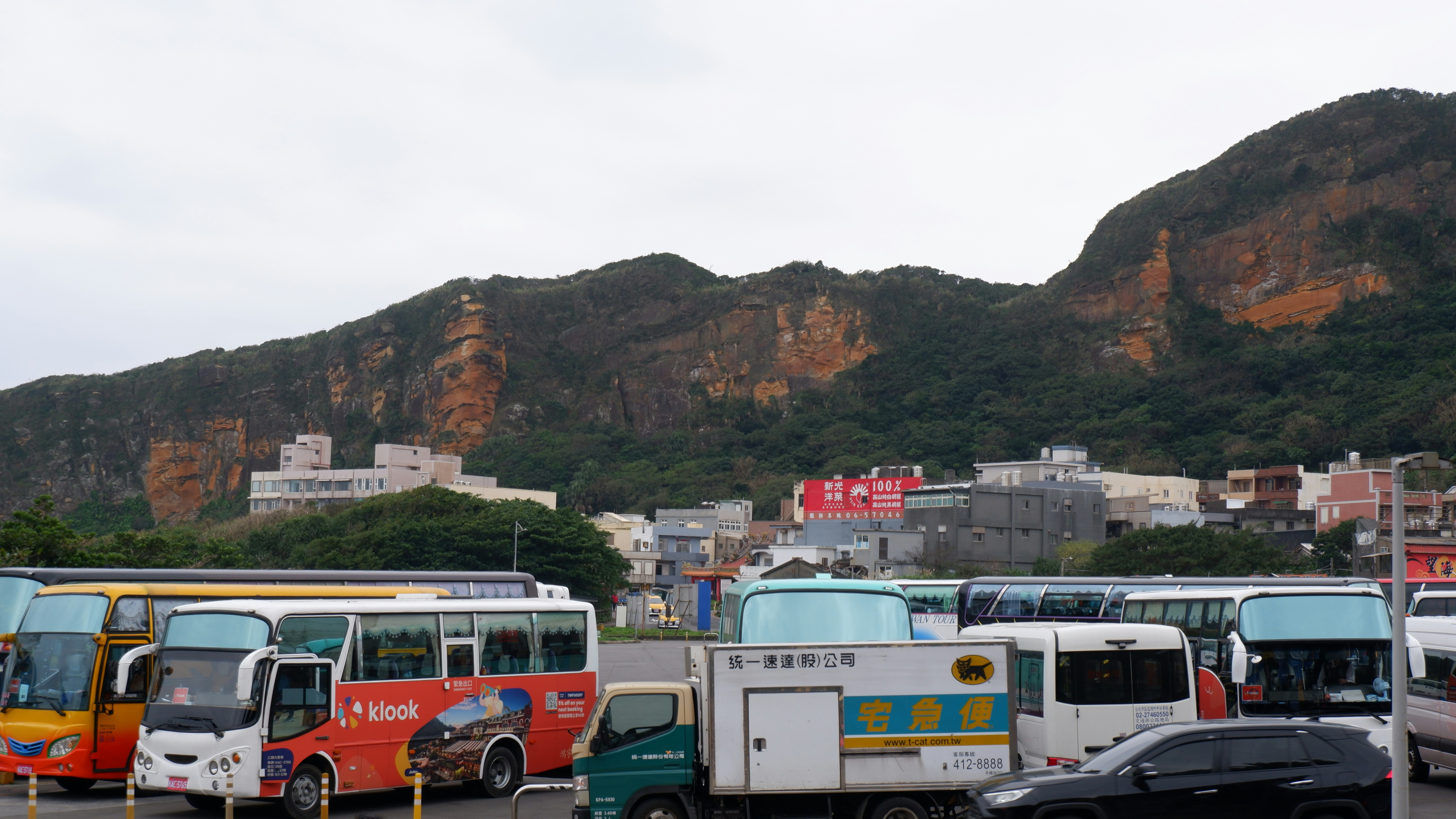 A parking lot filled with lots of different colored buses photo – Free ...