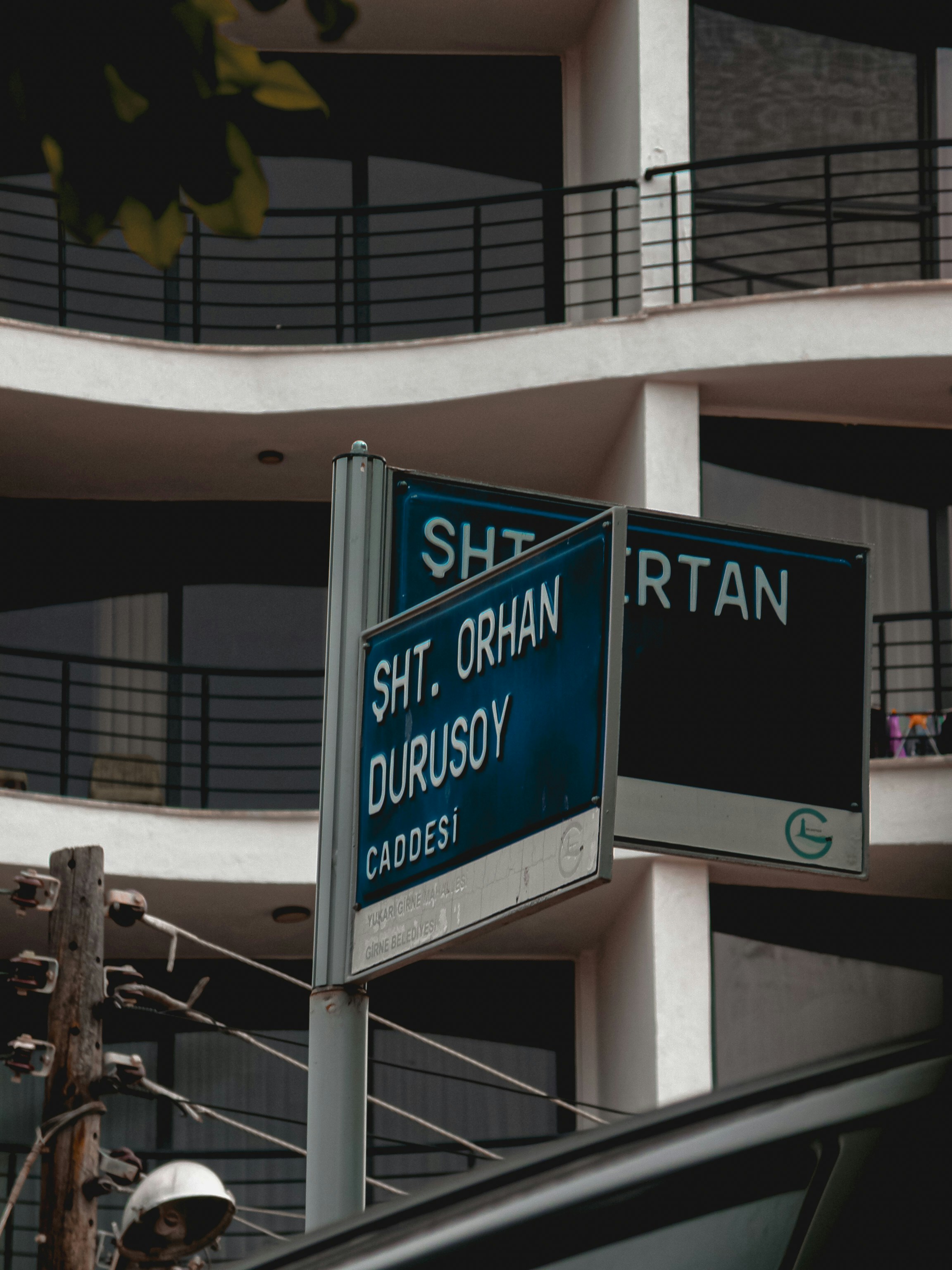 A street sign in front of a building with balconies photo – Free ...