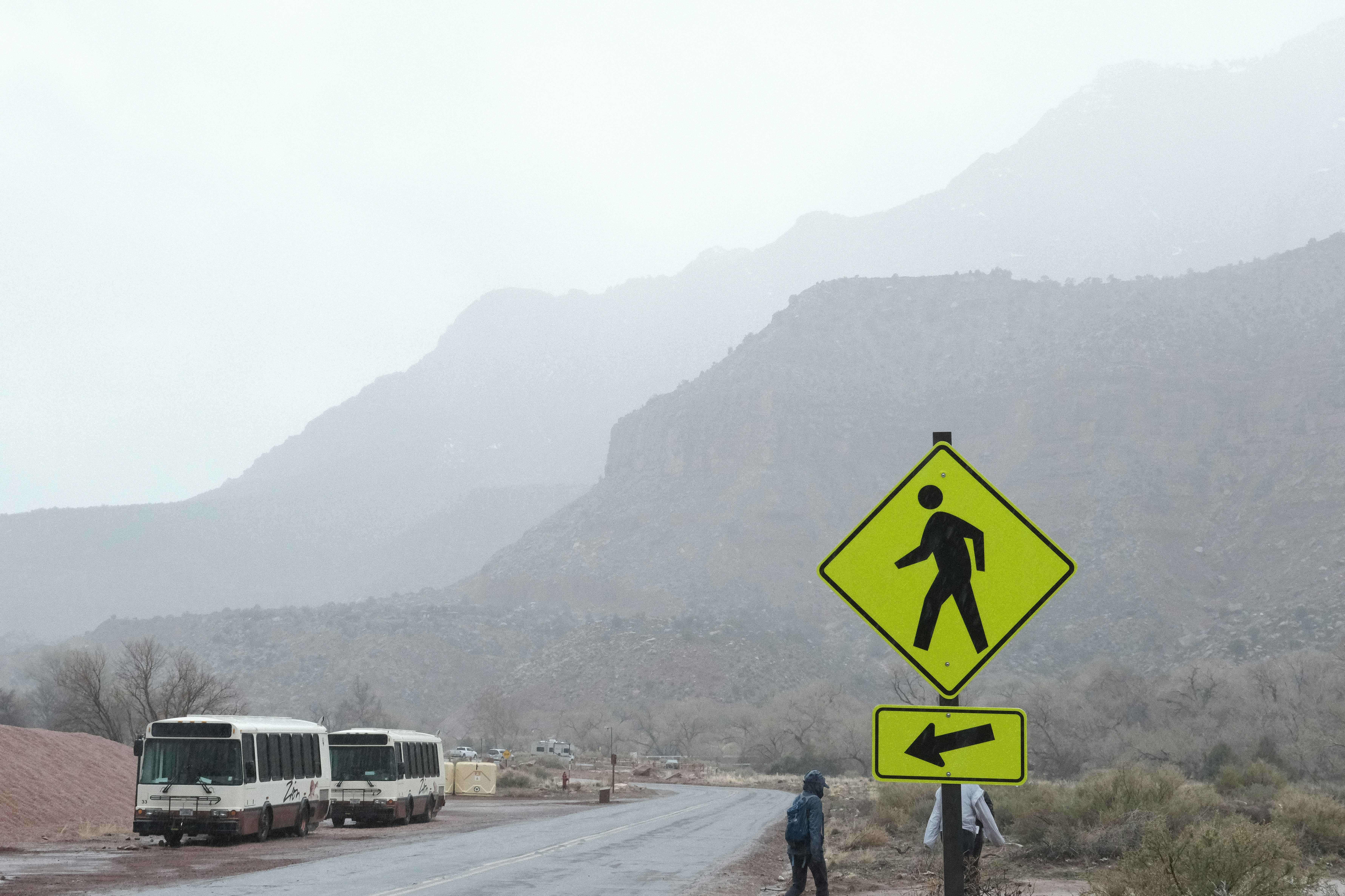 Desert Road Sentinel: A Bright Pedestrian Sign Amid Silent Peaks